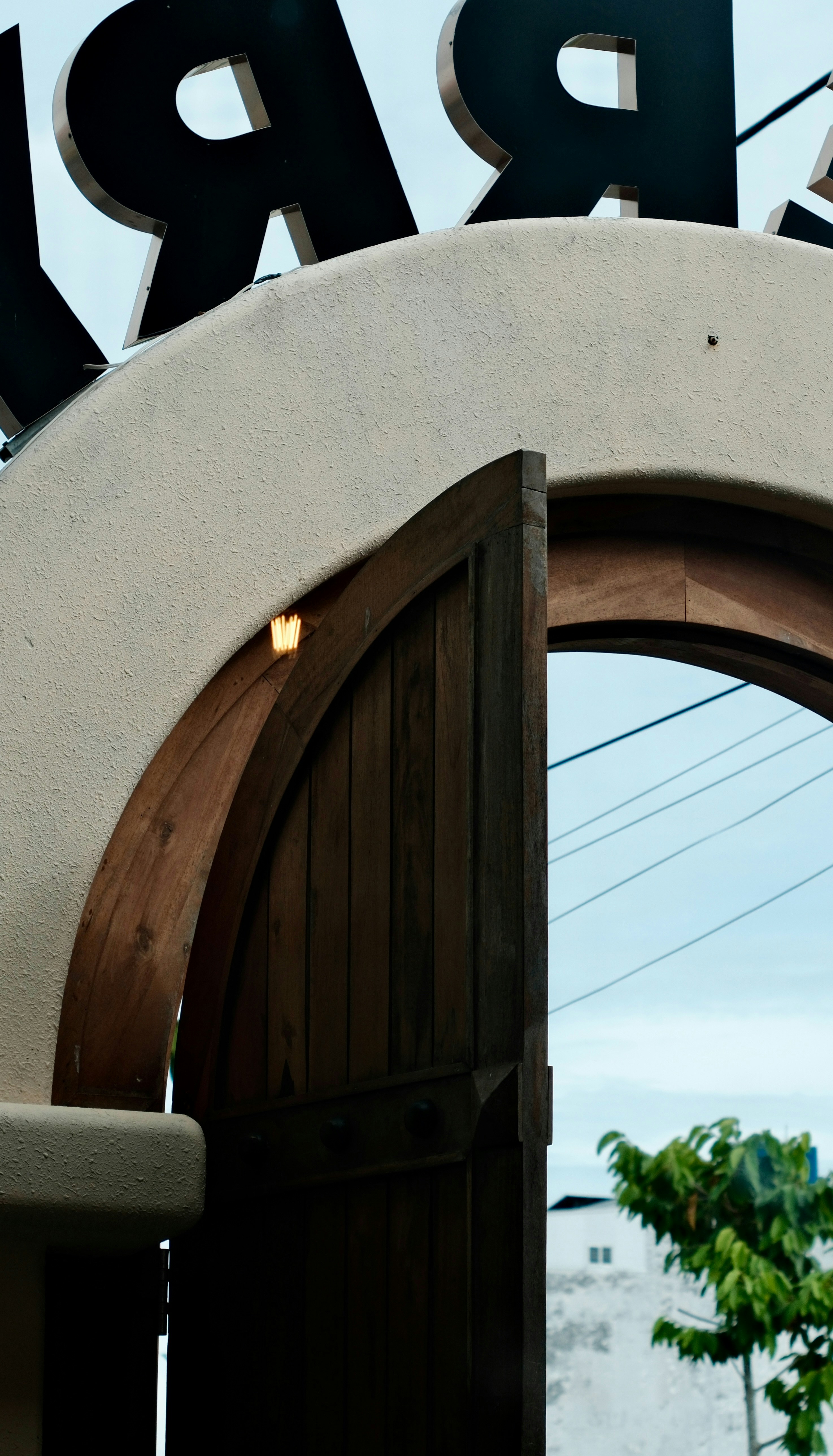 Arched Gateway with a Vertical Wooden Door Halved by Light