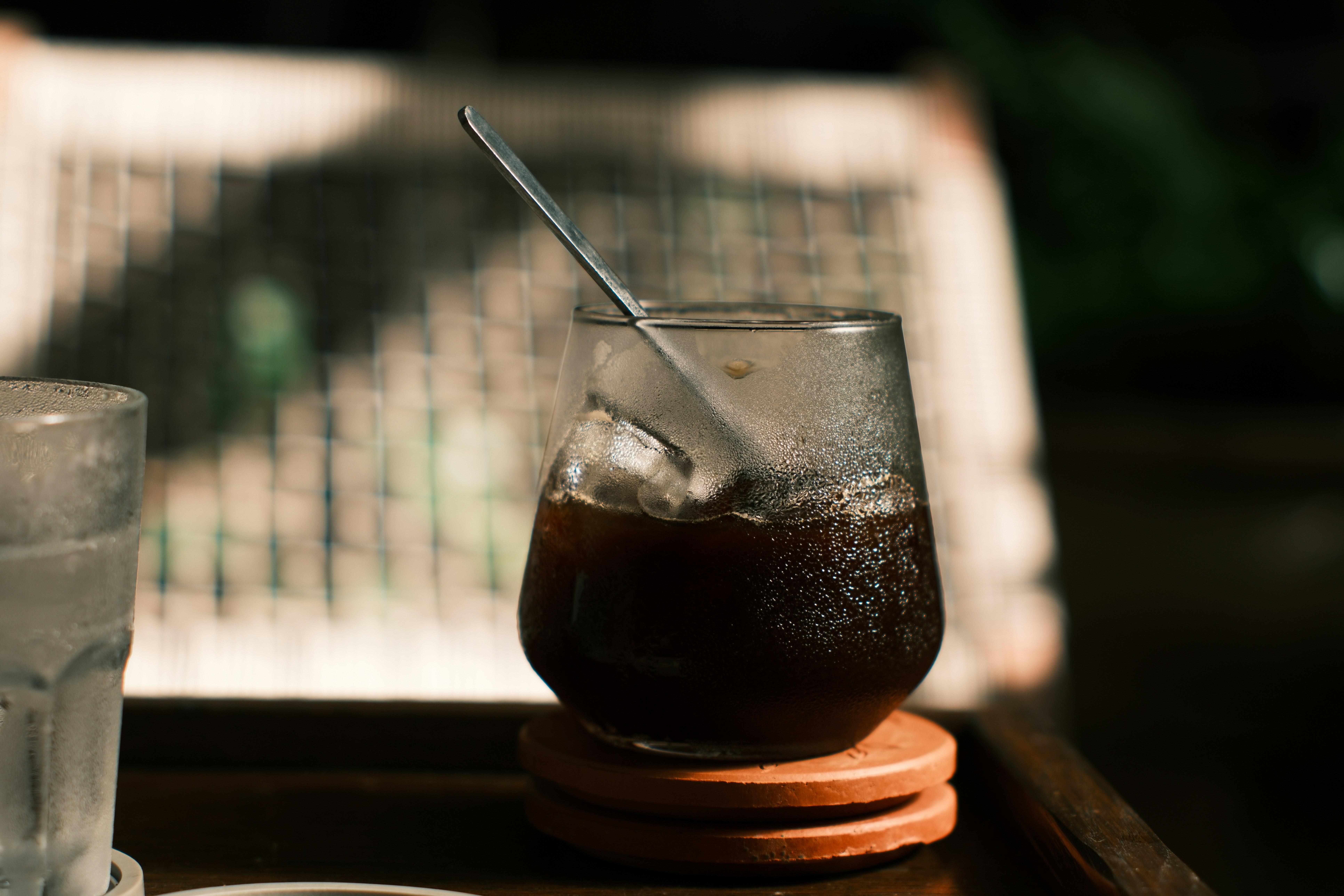 Liquid amber in the spotlight: a glassy centerpiece on a sunlit bar