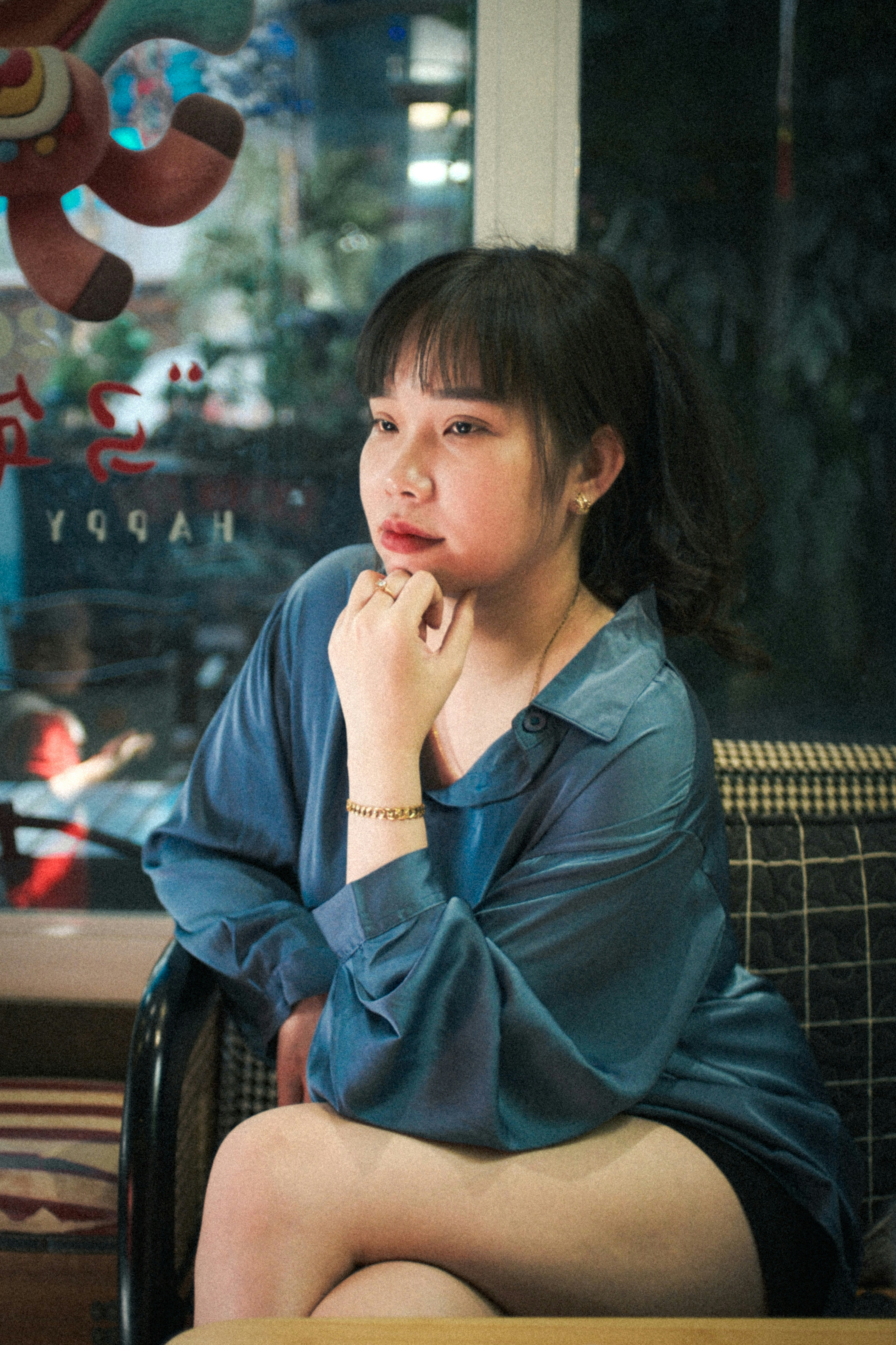  contemplative moment: a woman seated near a window in subdued blue hues