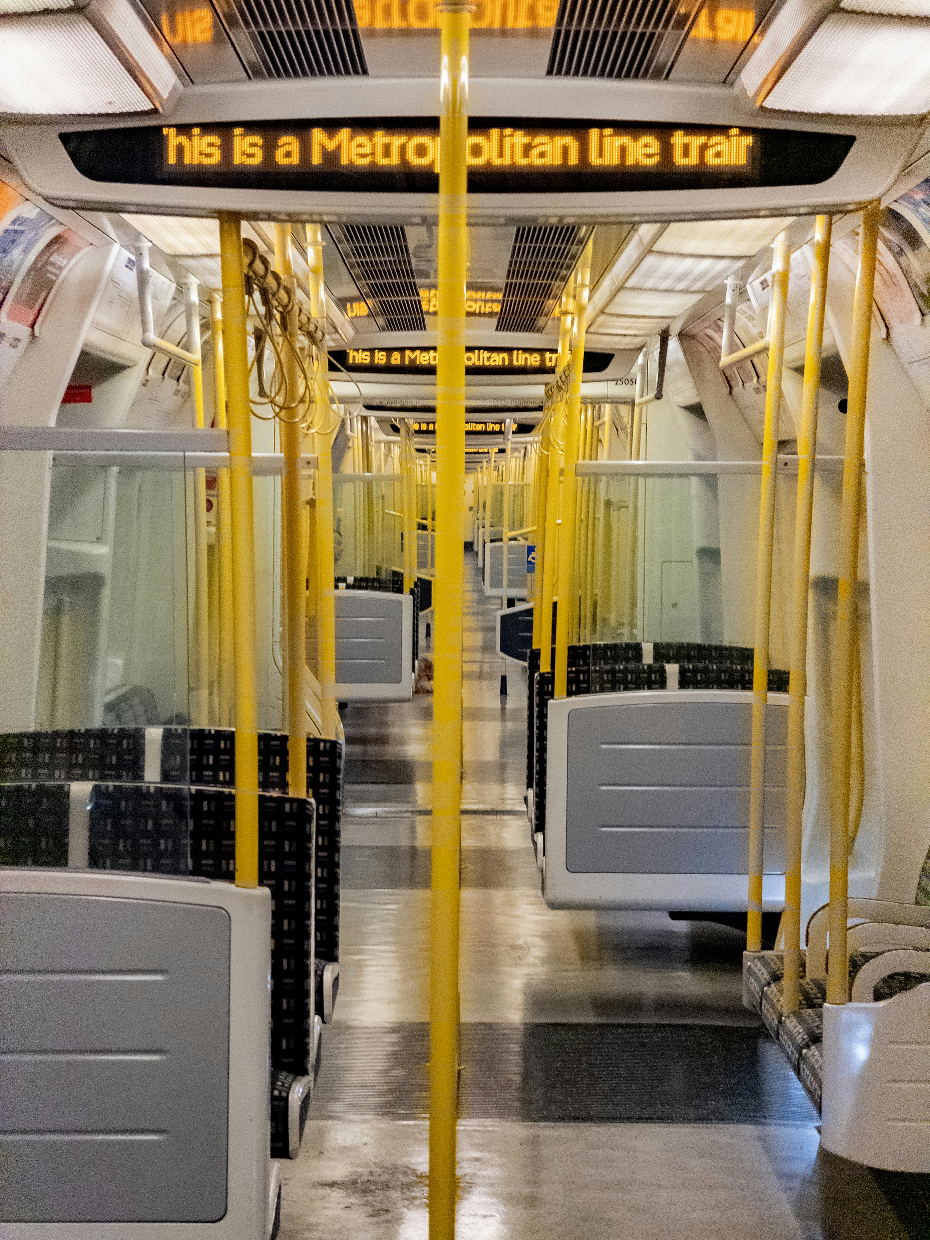 Vacant Metro Carriage: Symmetry, Yellow Poles, and Quiet Motion