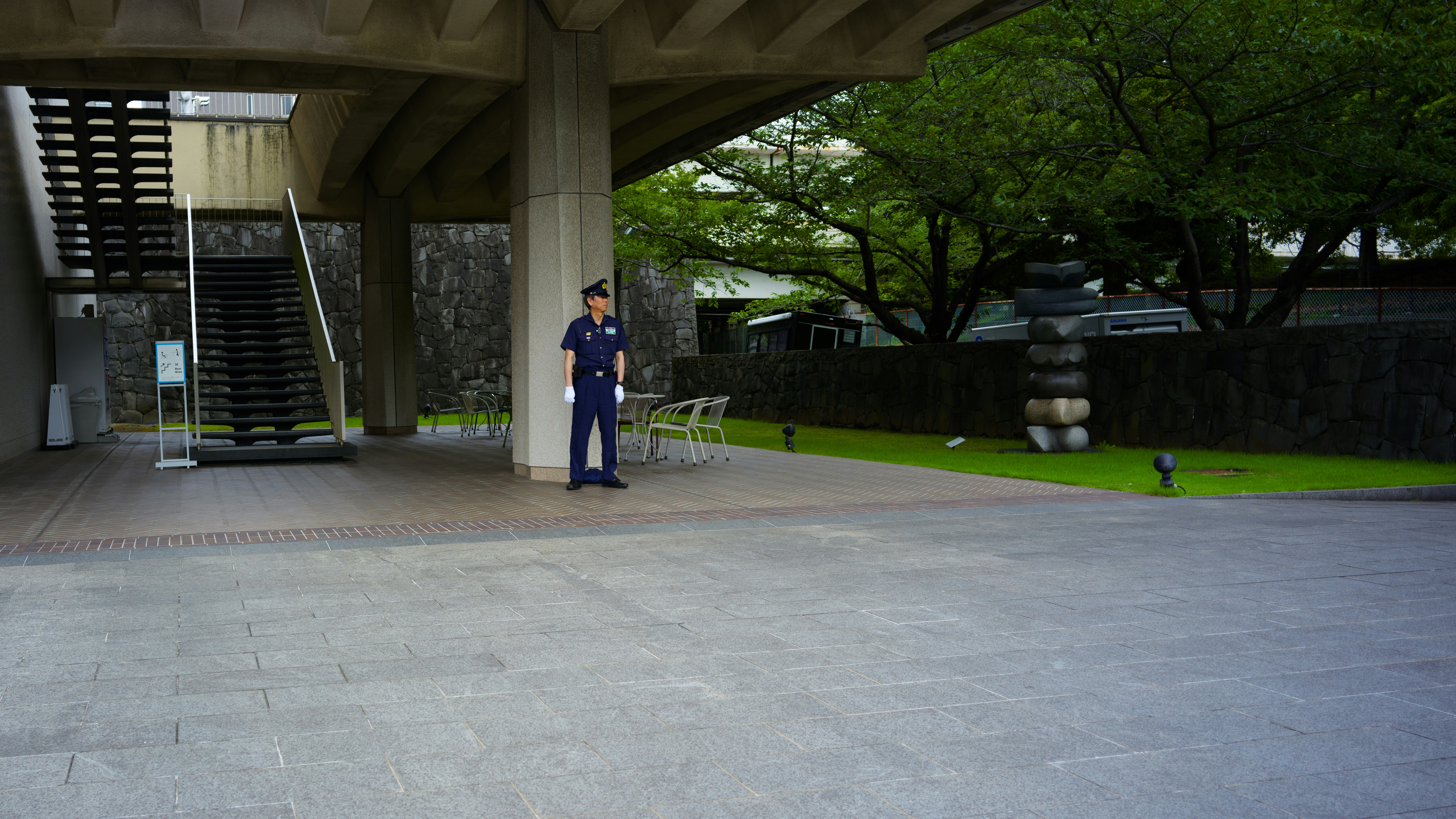 Guarded Quiet: A lone officer under the concrete canopy