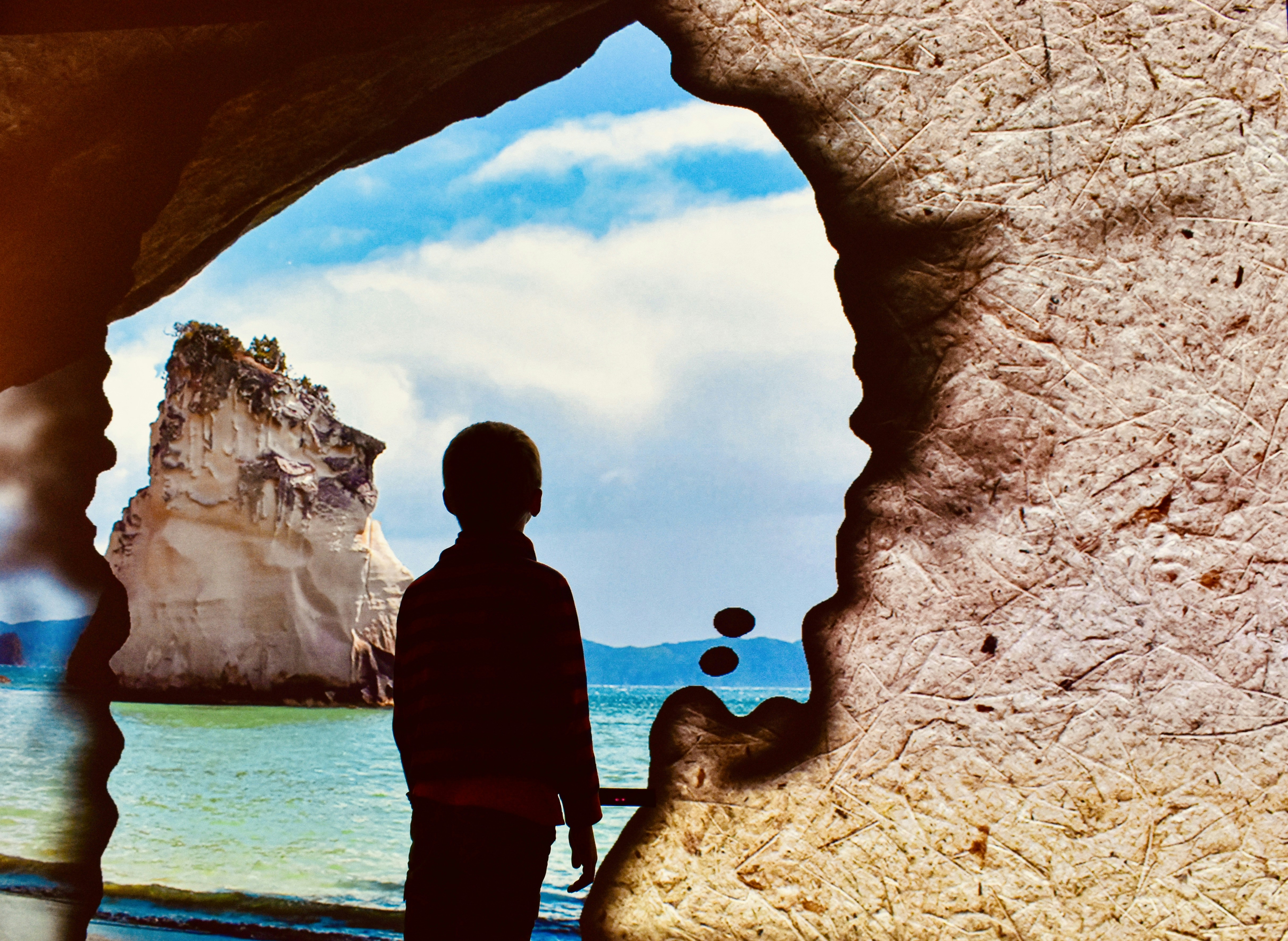 Silhouette at the Sea Cave: A Quiet Figure Framed by Natural Stone
