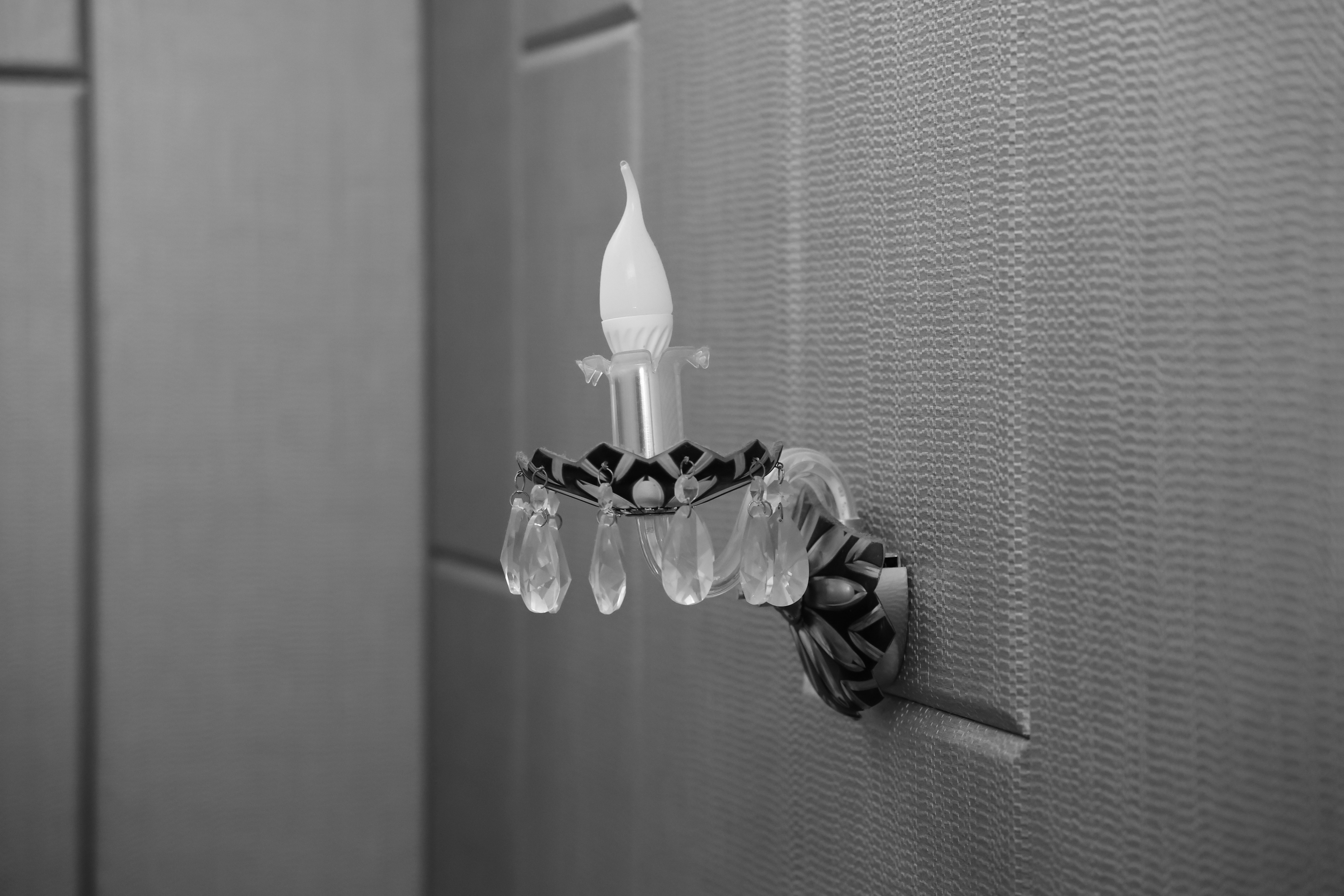 Crystal Tear: A Close-Up of the Hanging Ornament on a Textured Door