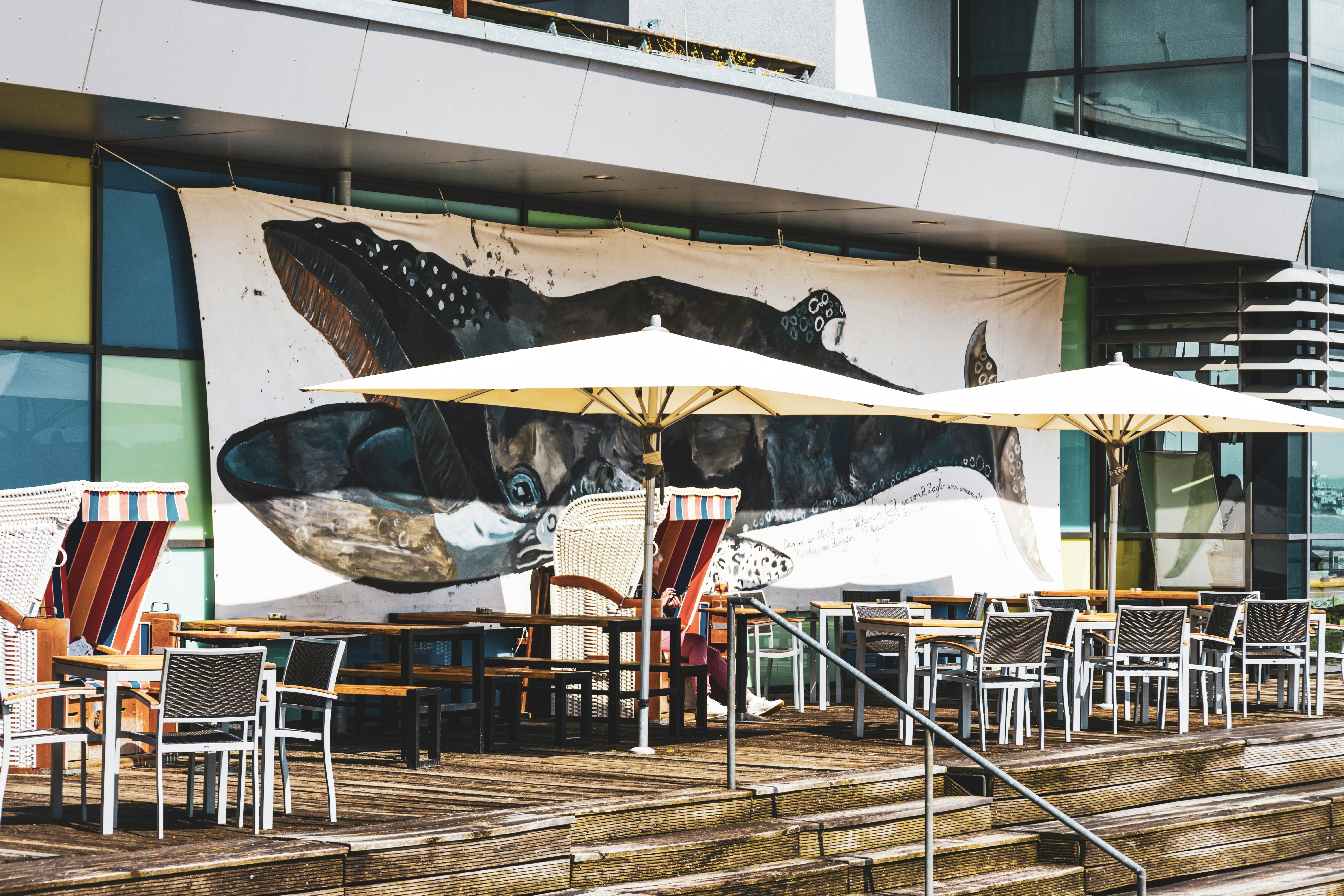 Whale Mural Meets Outdoor Café: A Sunlit Deck Scene