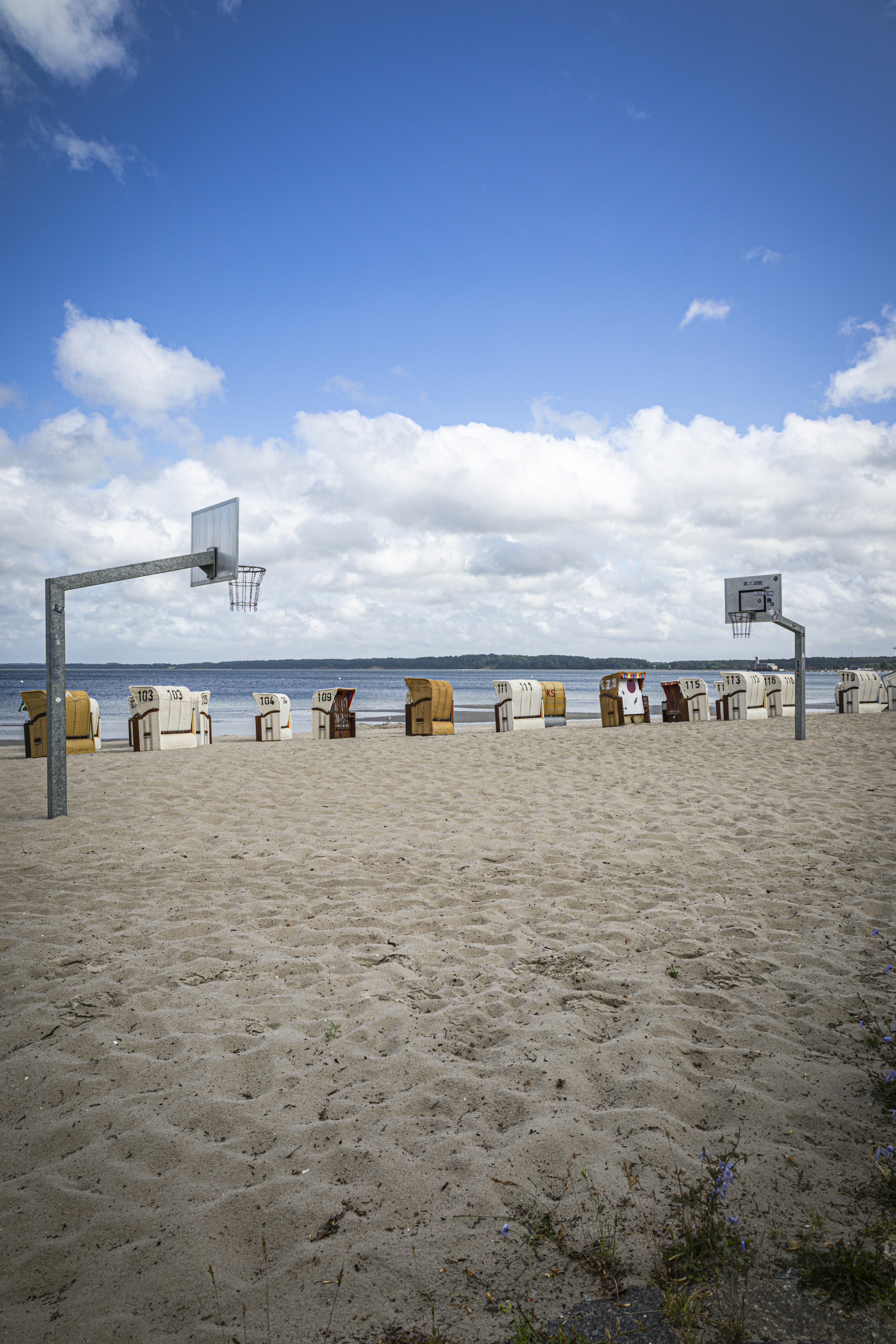 Basketball nets in a sunlit seaside sandscape