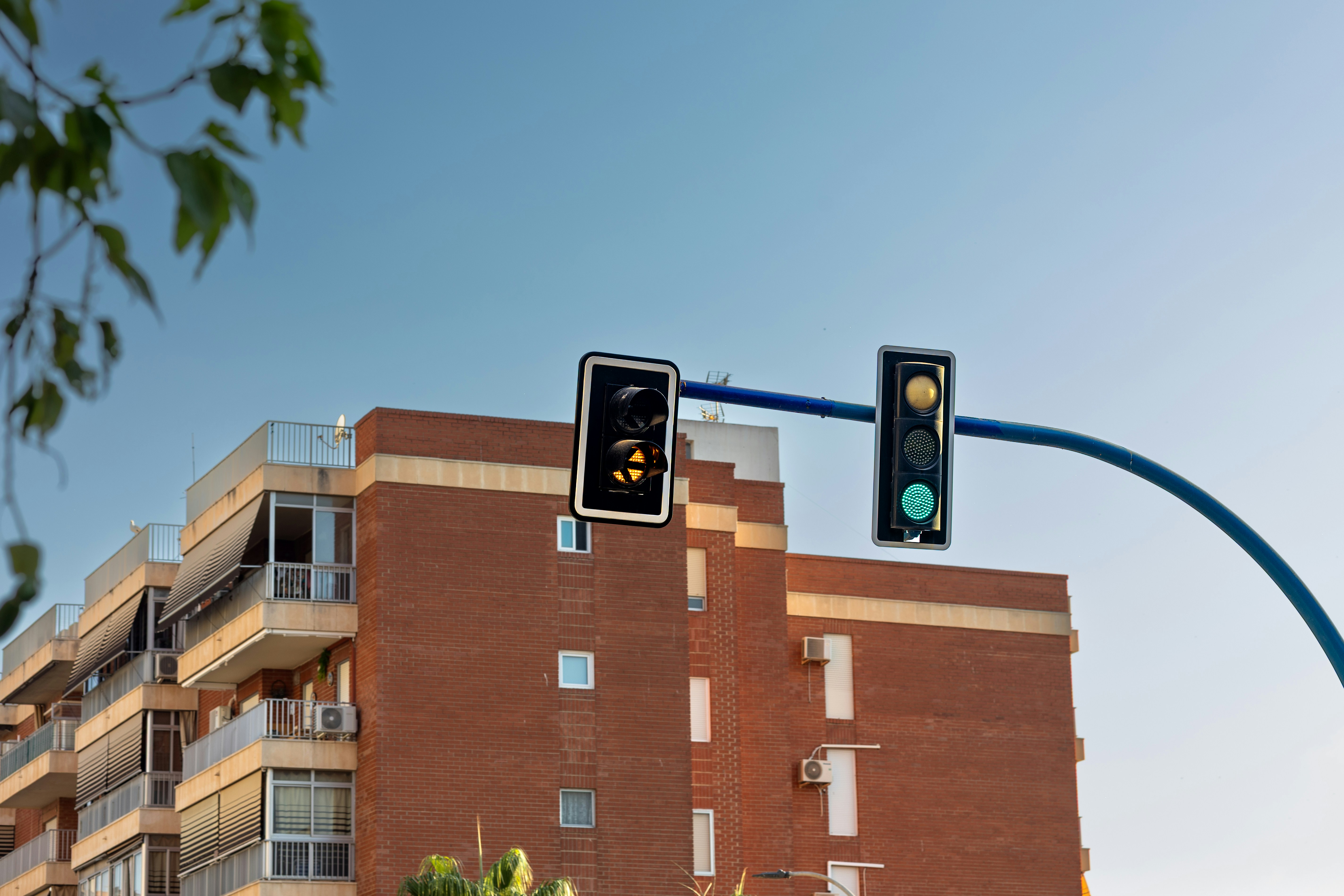 Urban Traffic Light Framed by Red Brick Apartment Block