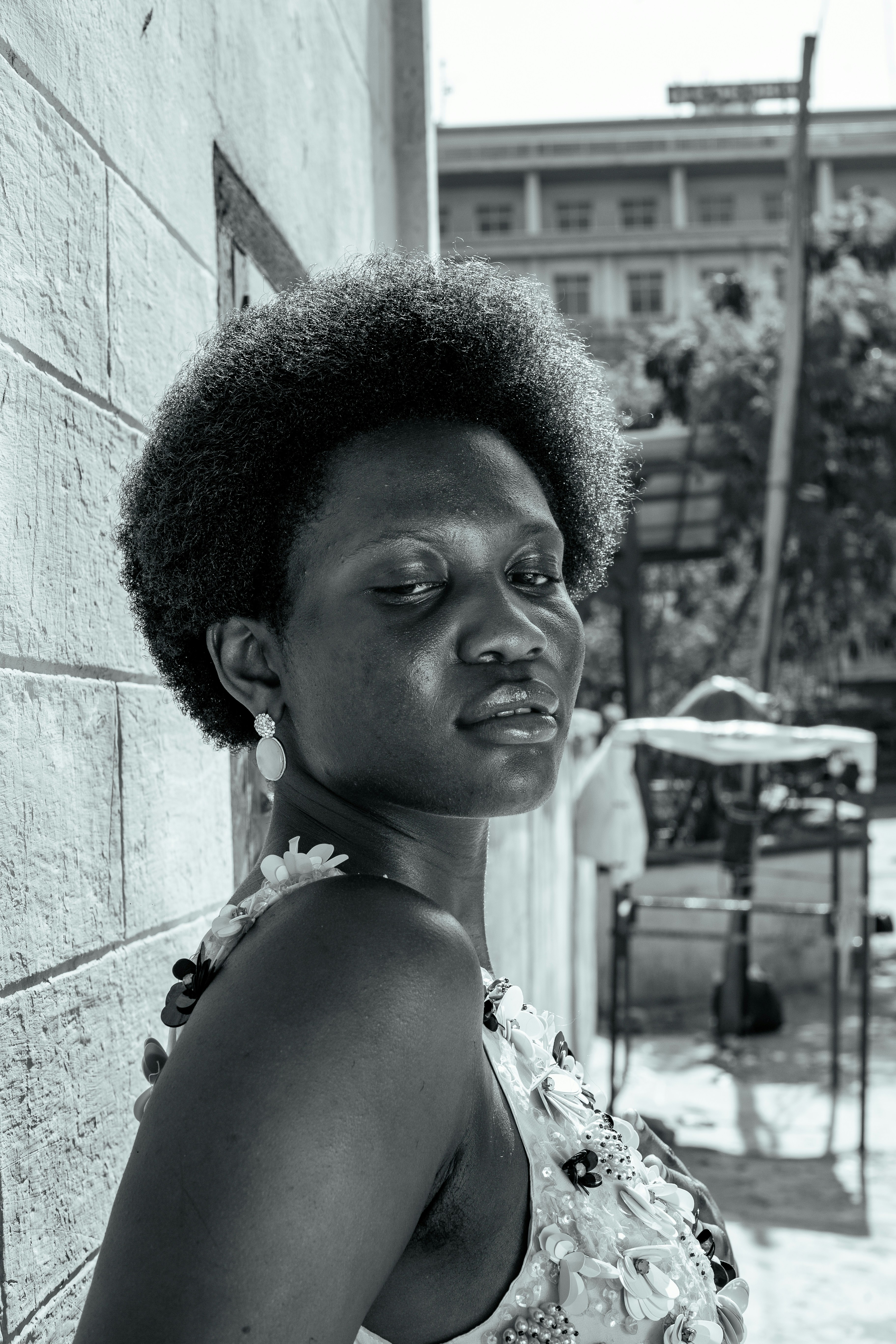 Portrait in Shade: A Confident Gaze Against a City Backdrop