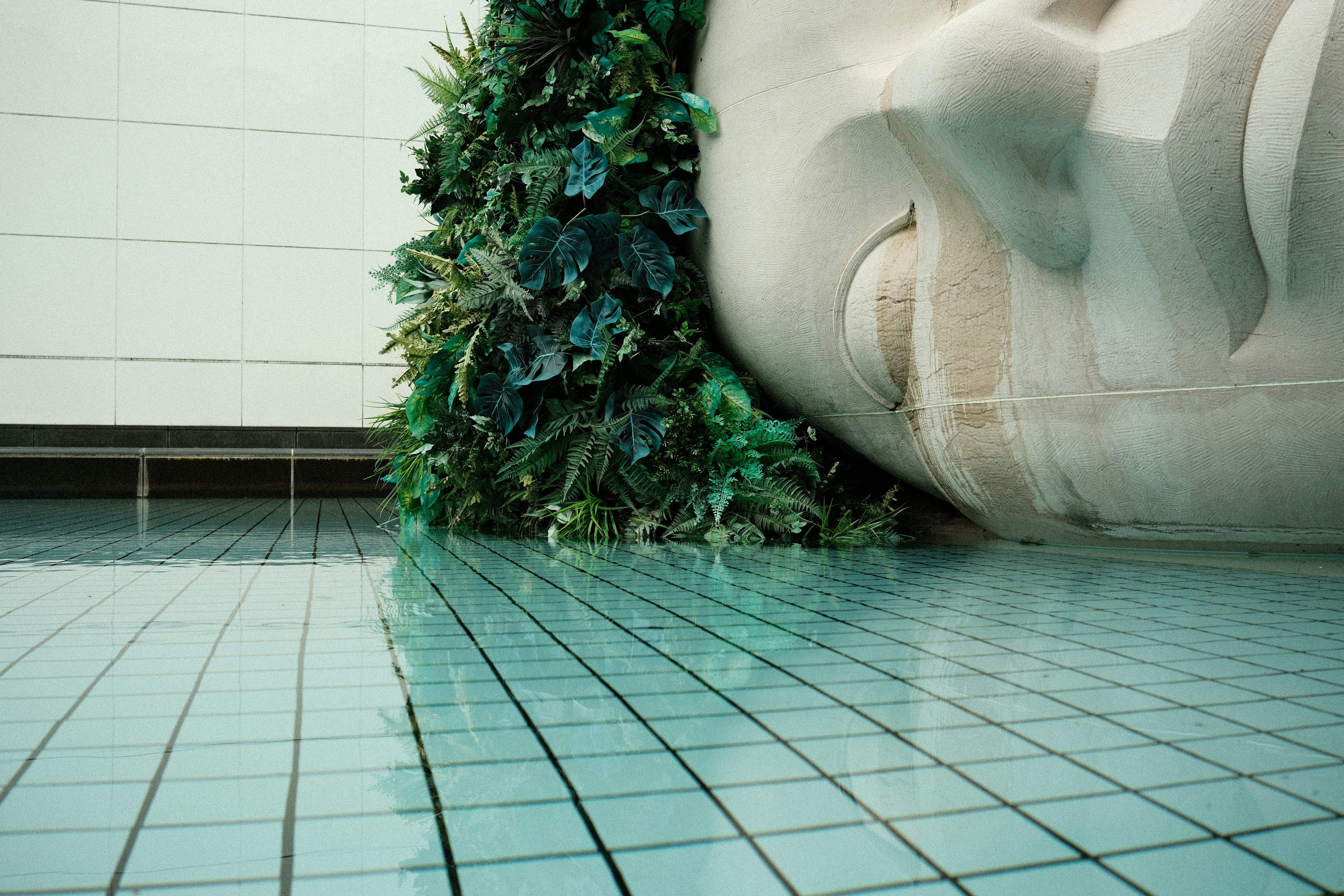 Zen Pool Edge: Concrete Sculpture and Ivy Meet the Reflective Tiles
