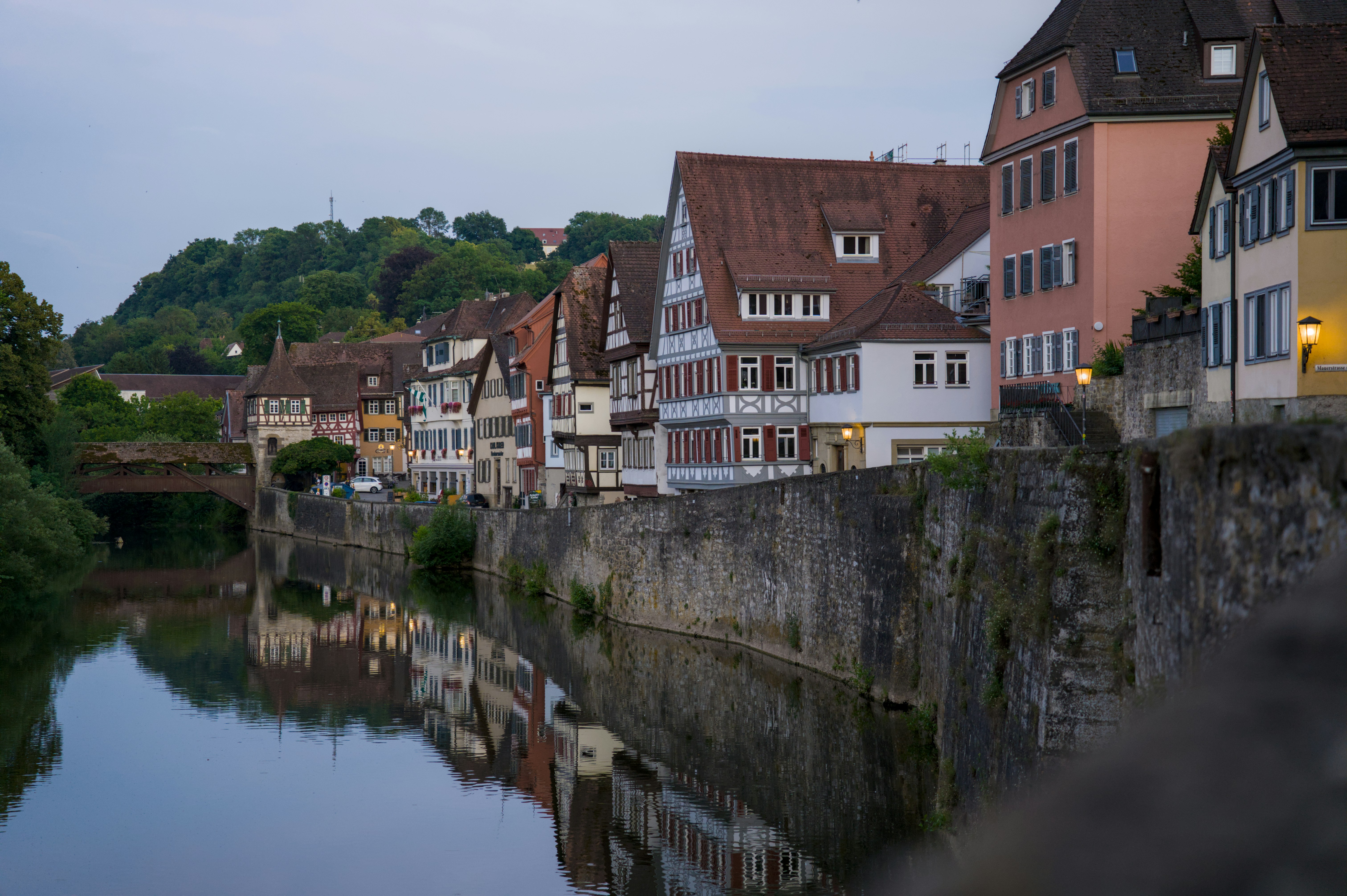 Timbered row along the river: a quiet European town reflected in calm waters