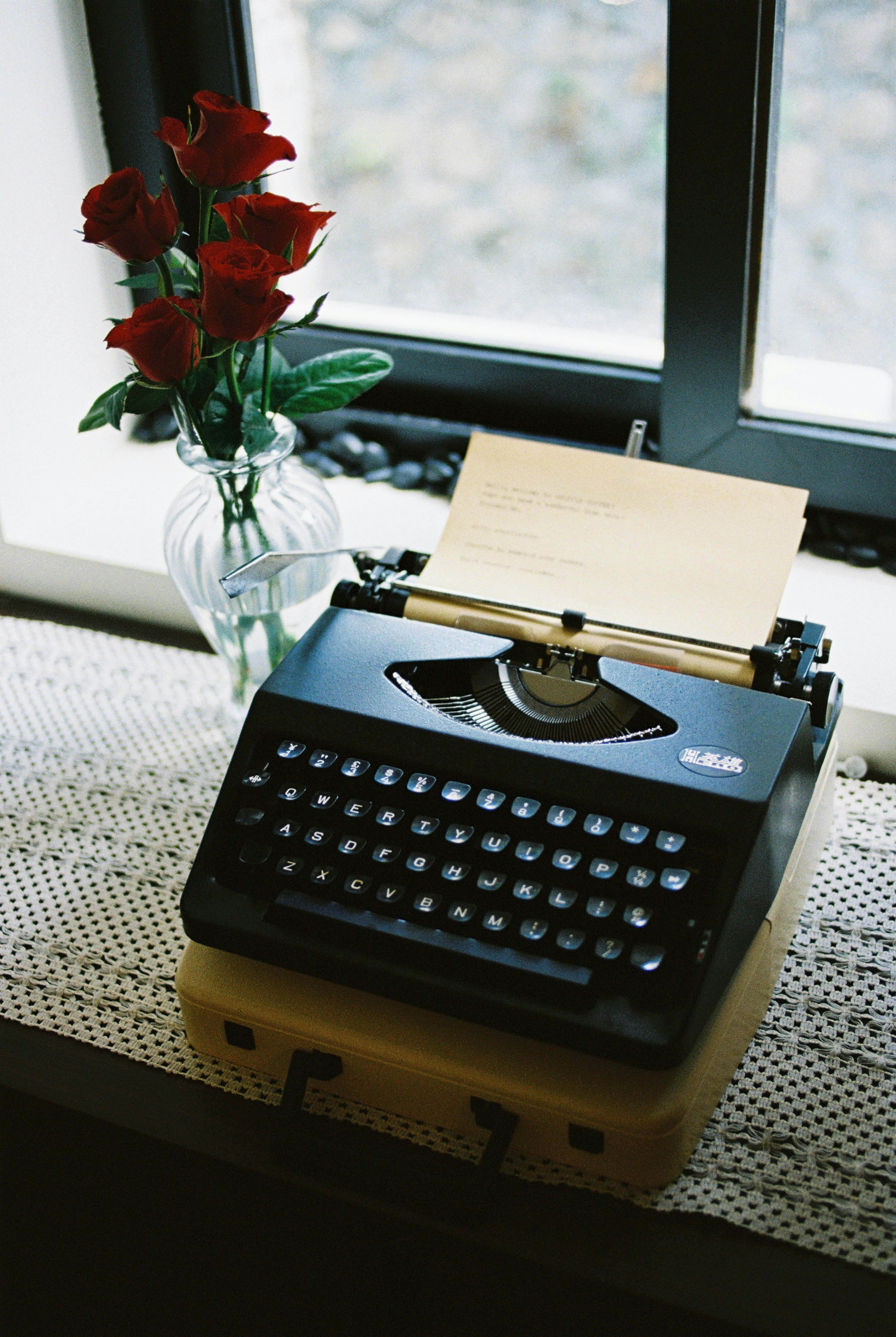 Red Rose Ode on a Desk: Vintage Typewriter in a Quiet Window Light