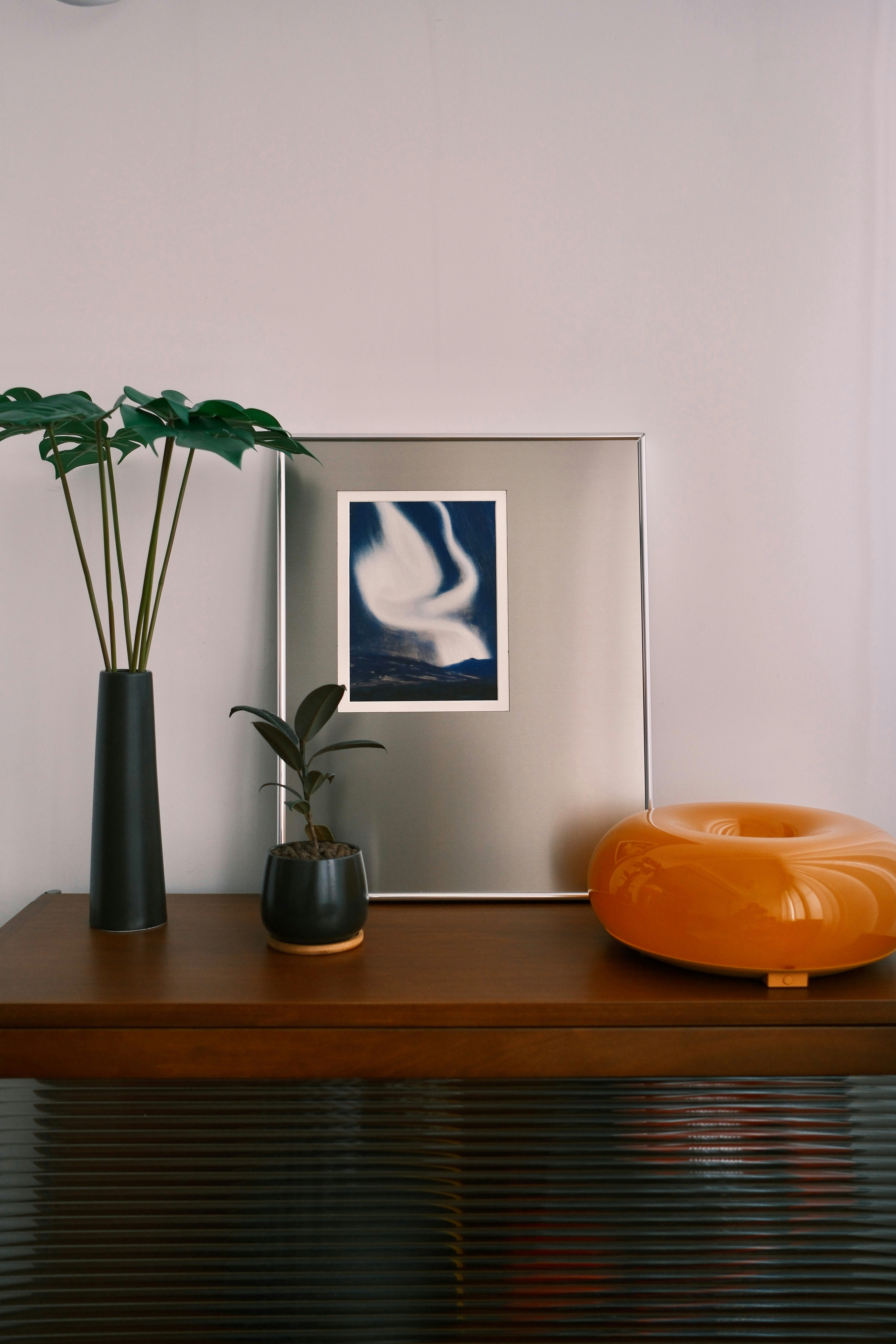 Ceramic Orange Ring and Framed Perspective on a Minimal Shelf
