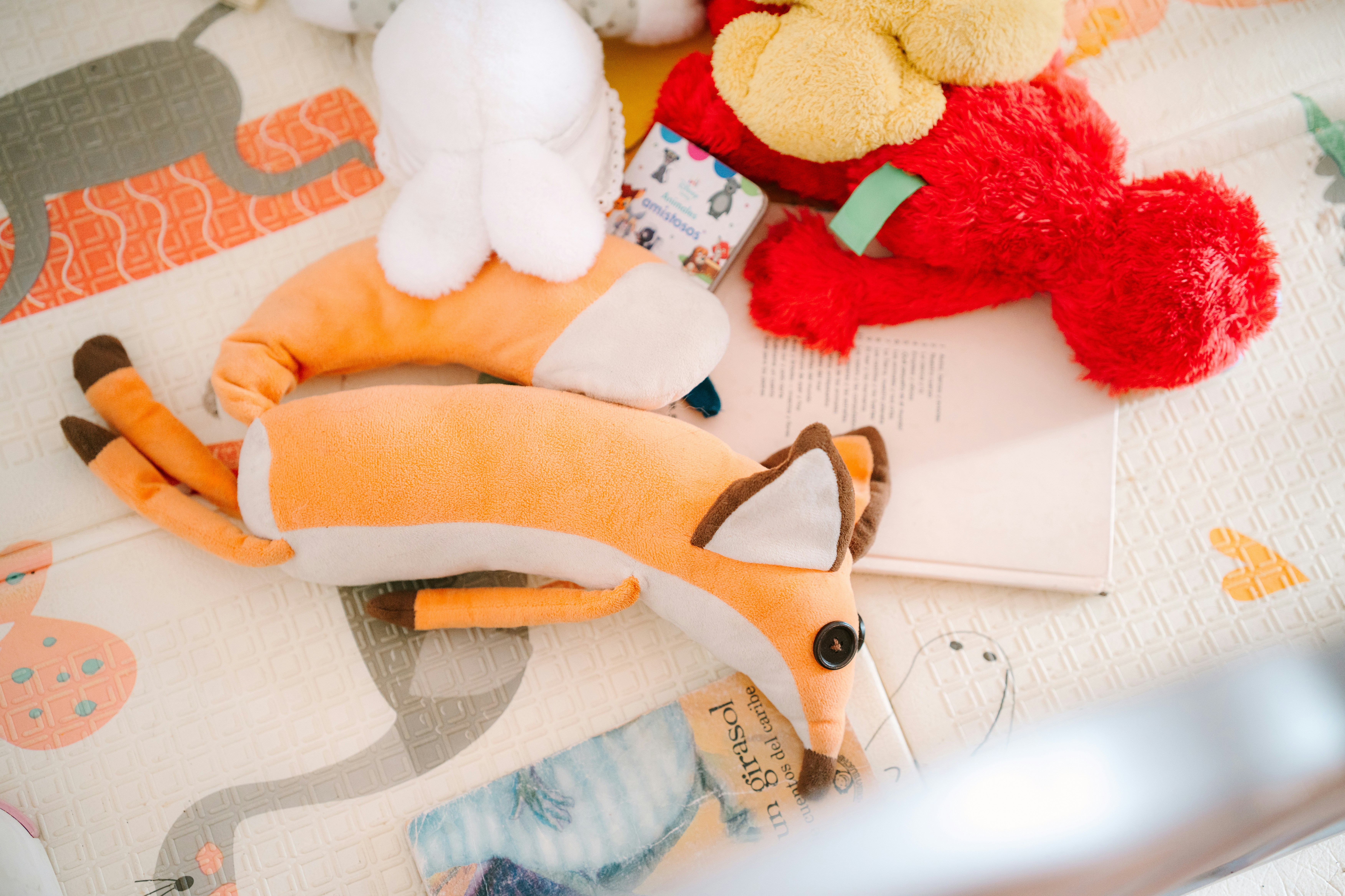 Whimsical plush fox napping among colorful toys