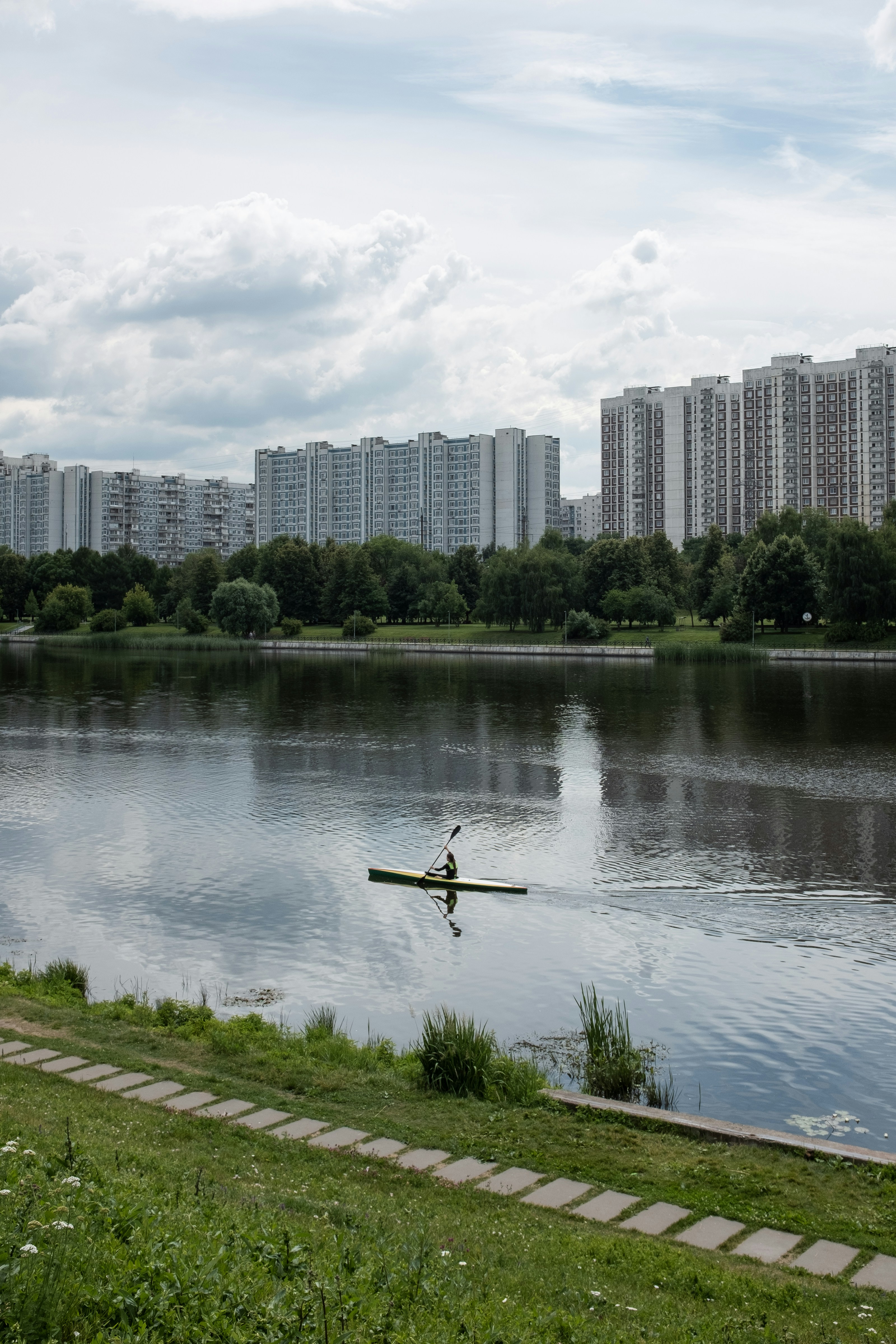 Paddle Across Reflections: A Lone Kayaker on a City Lake