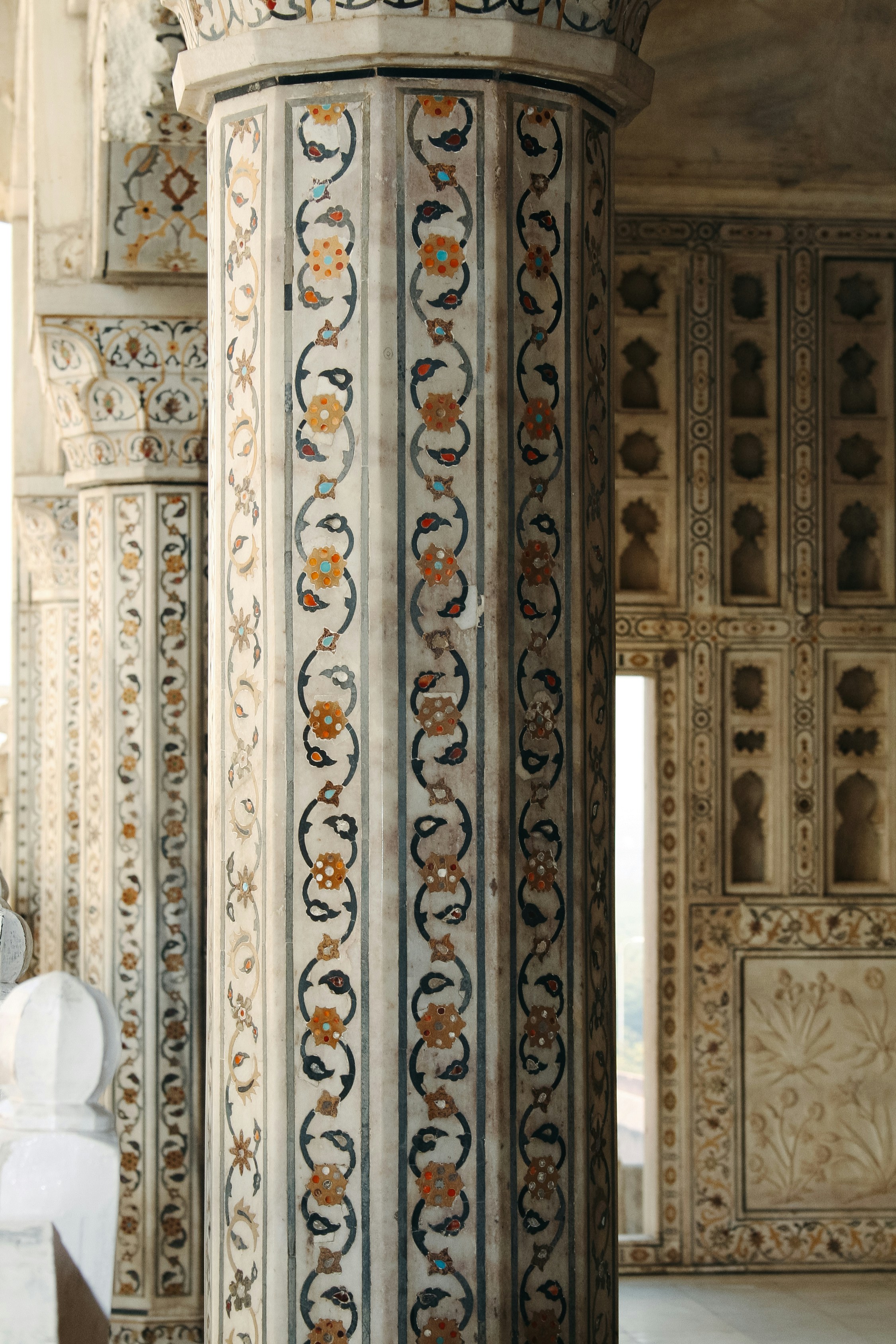 Intricately decorated stone columns with vertical floral motifs and ornate carvings, framed within a historic architectural interior.