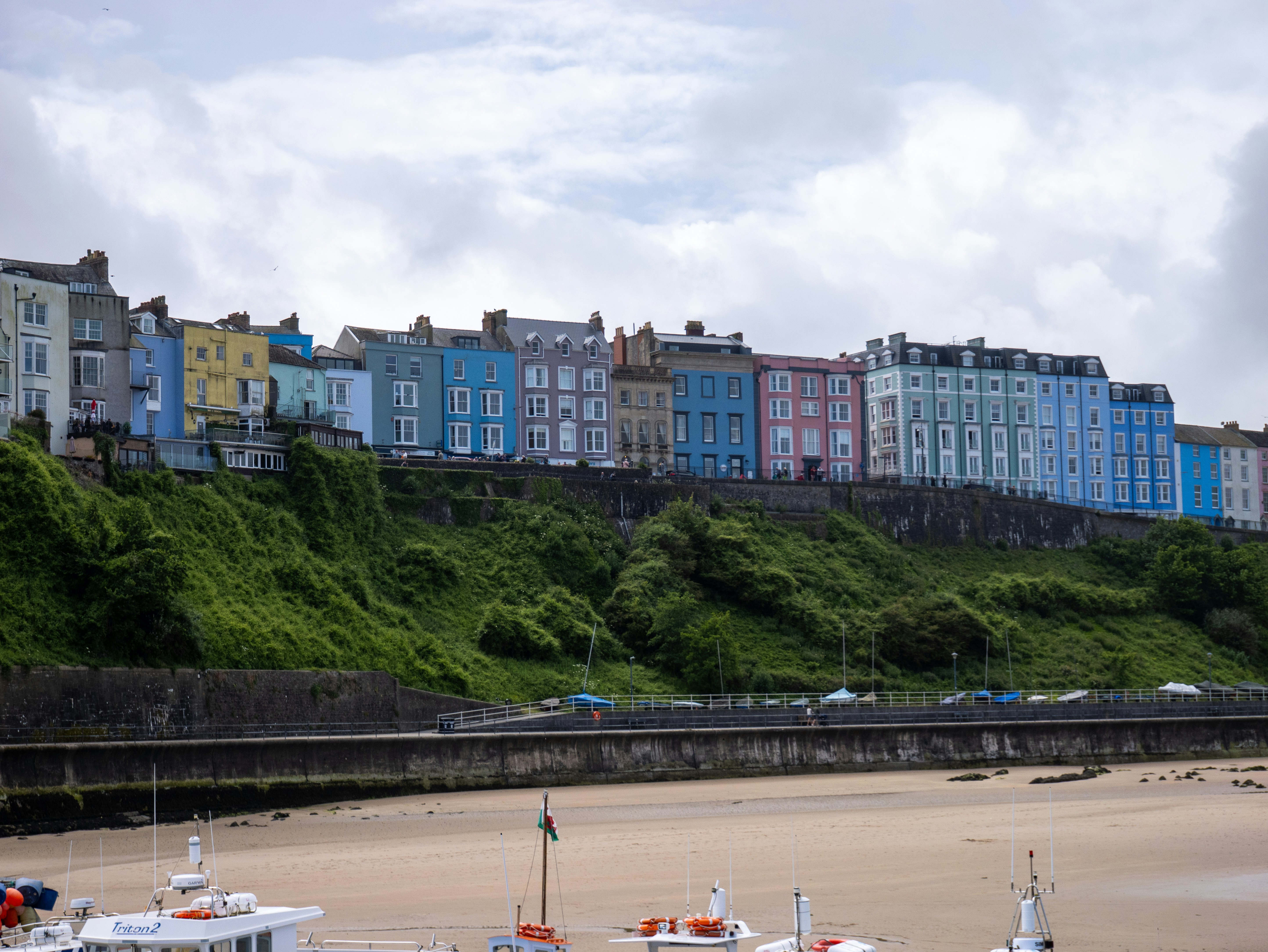 Row of pastel townhouses along a cliff-top shoreline