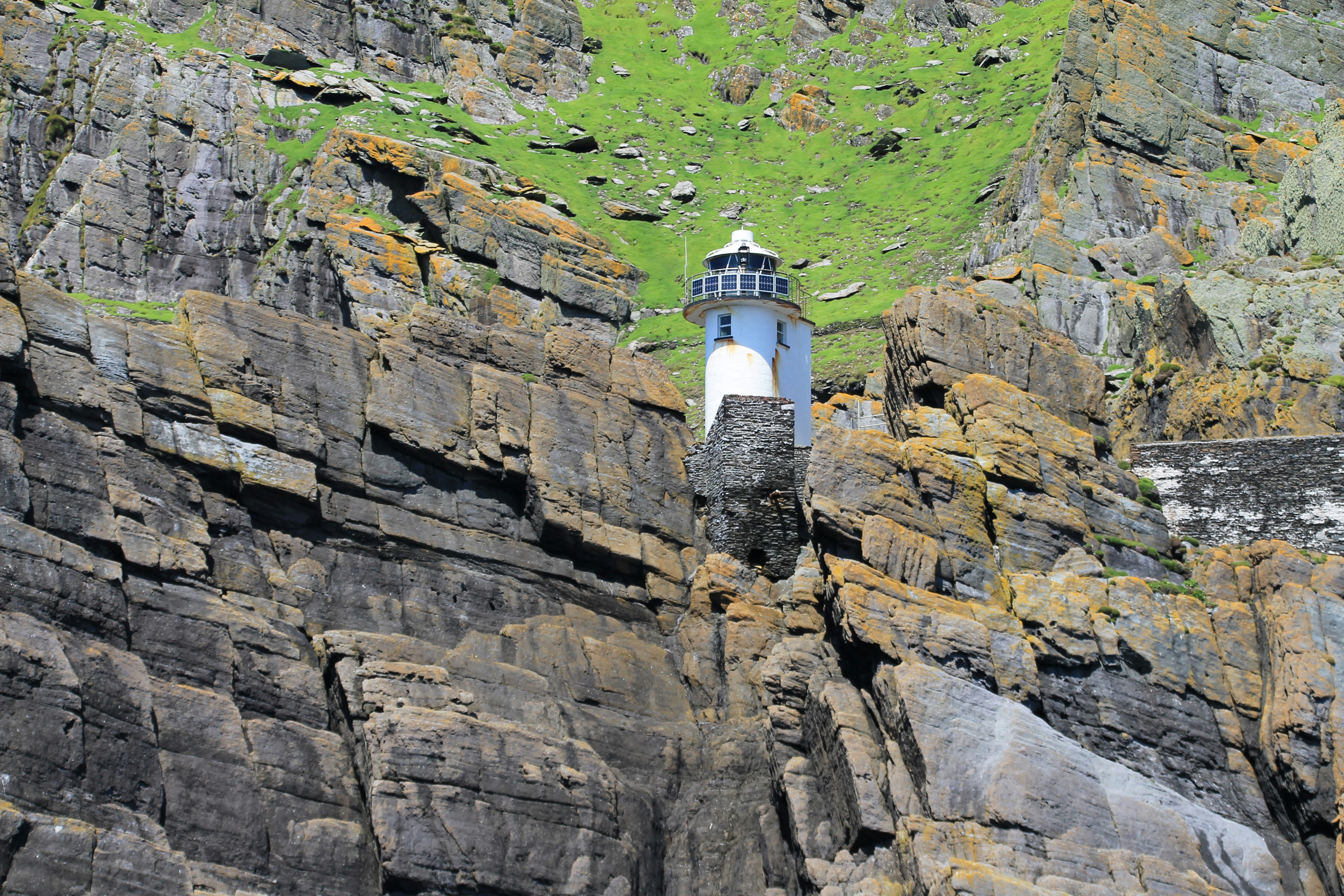 Cliffside Beacon: A Lone Lighthouse Resting on Weathered Stone