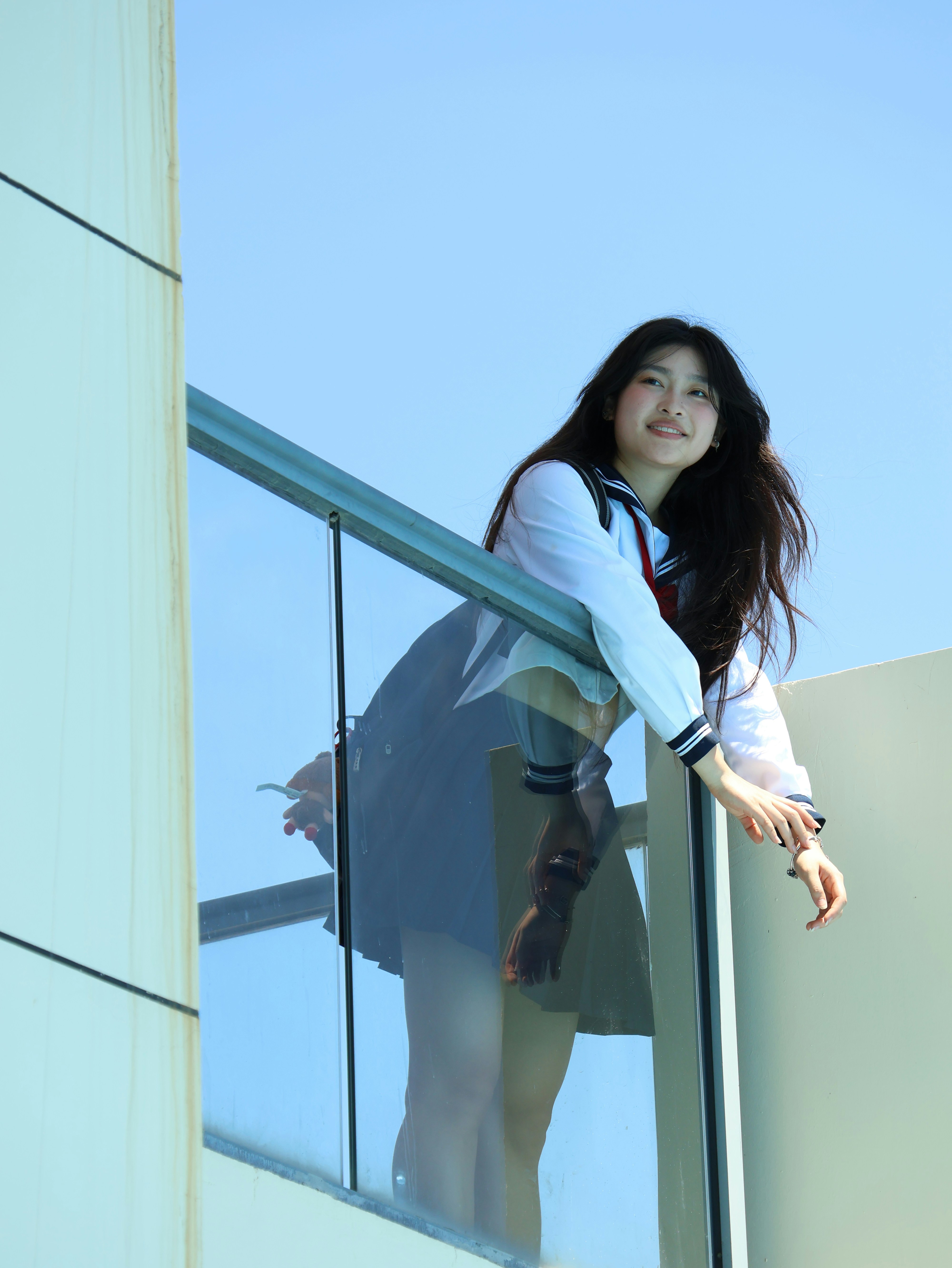 Skybound Smile: A Student’s Quiet Balance on the Balcony Rail