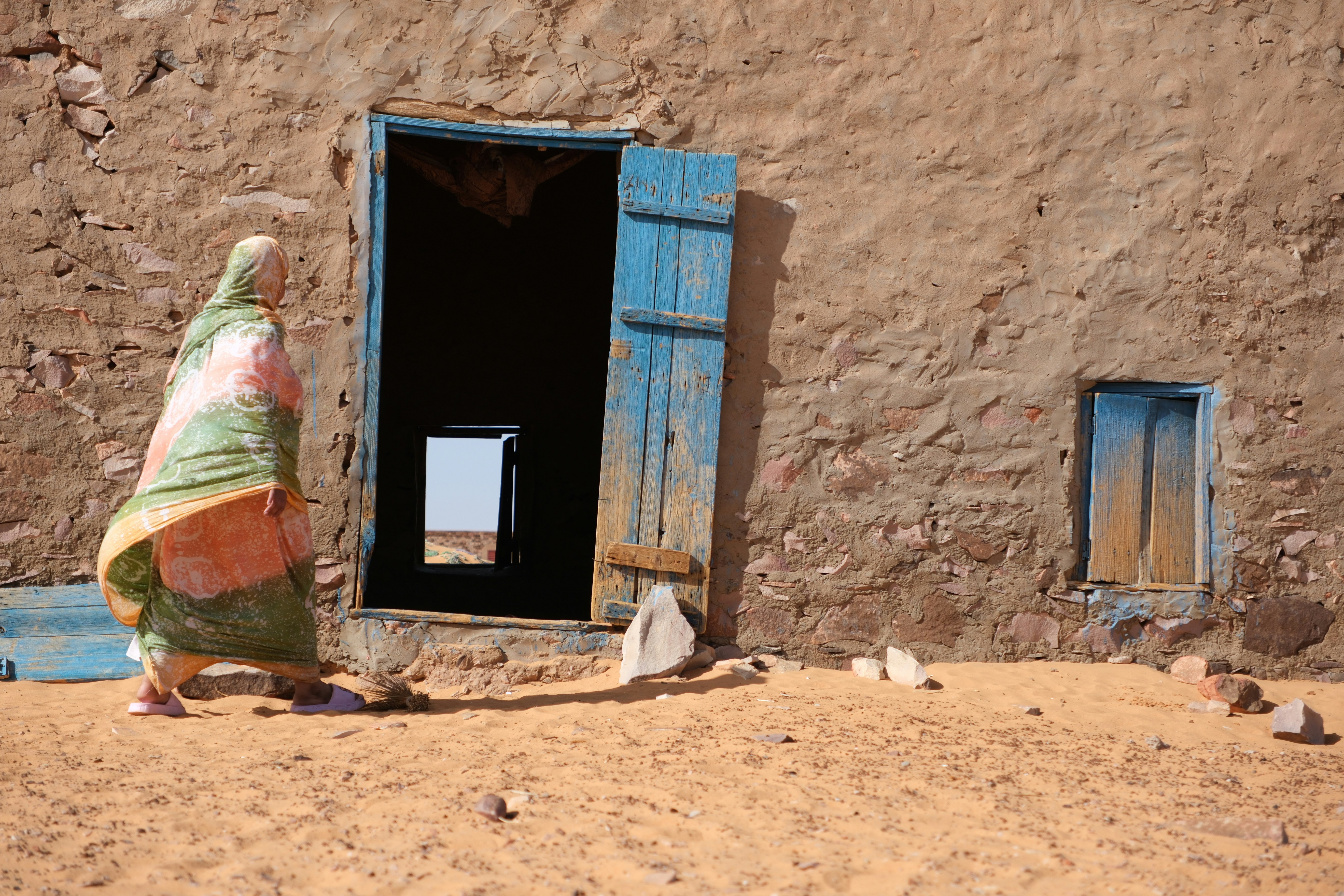 Barefoot Traveler and a Weathered Doorway in a Deserted House