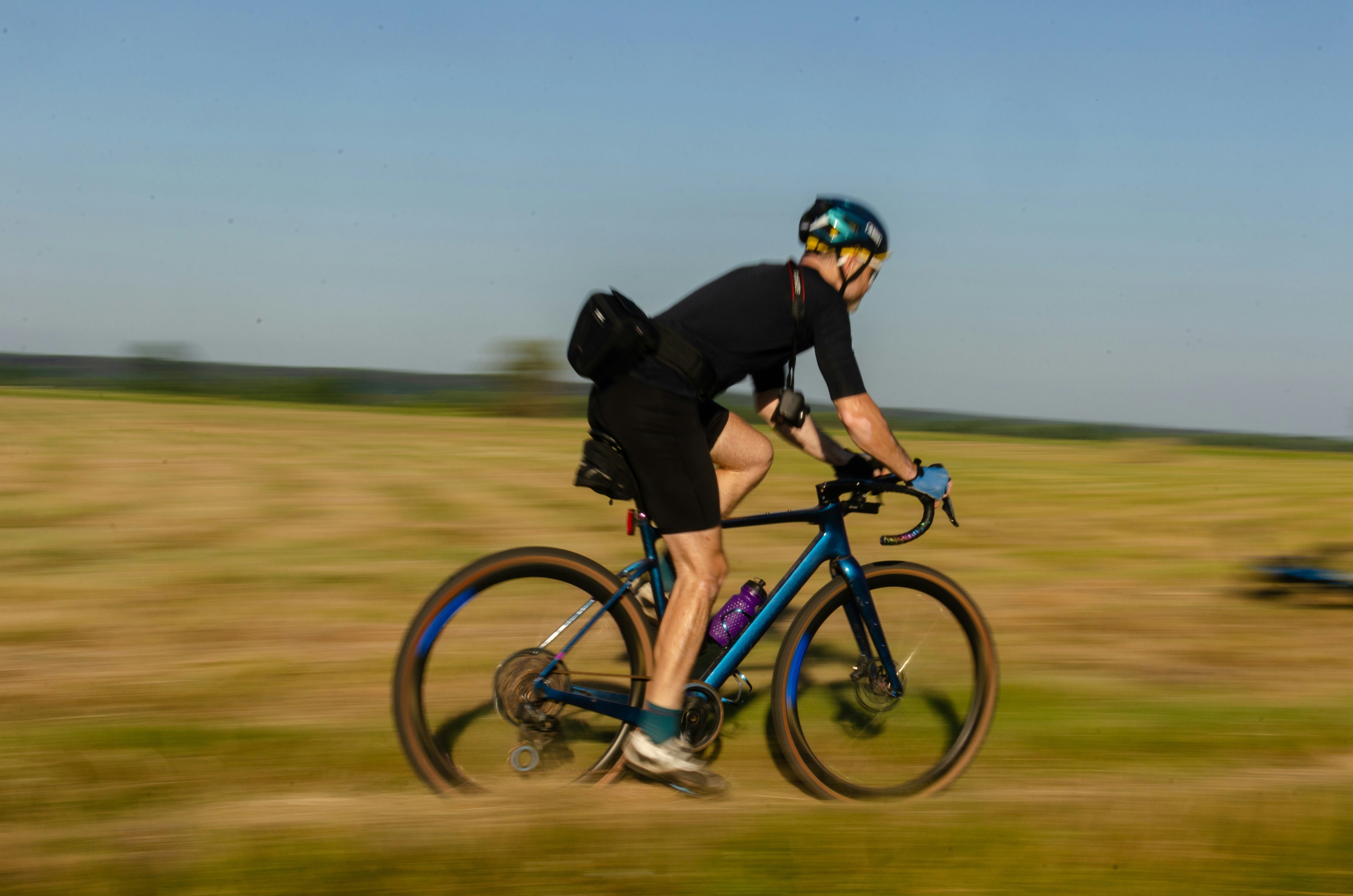 Winged Wheel in a Gentle Blur: Cyclist Racing Across Open Plains