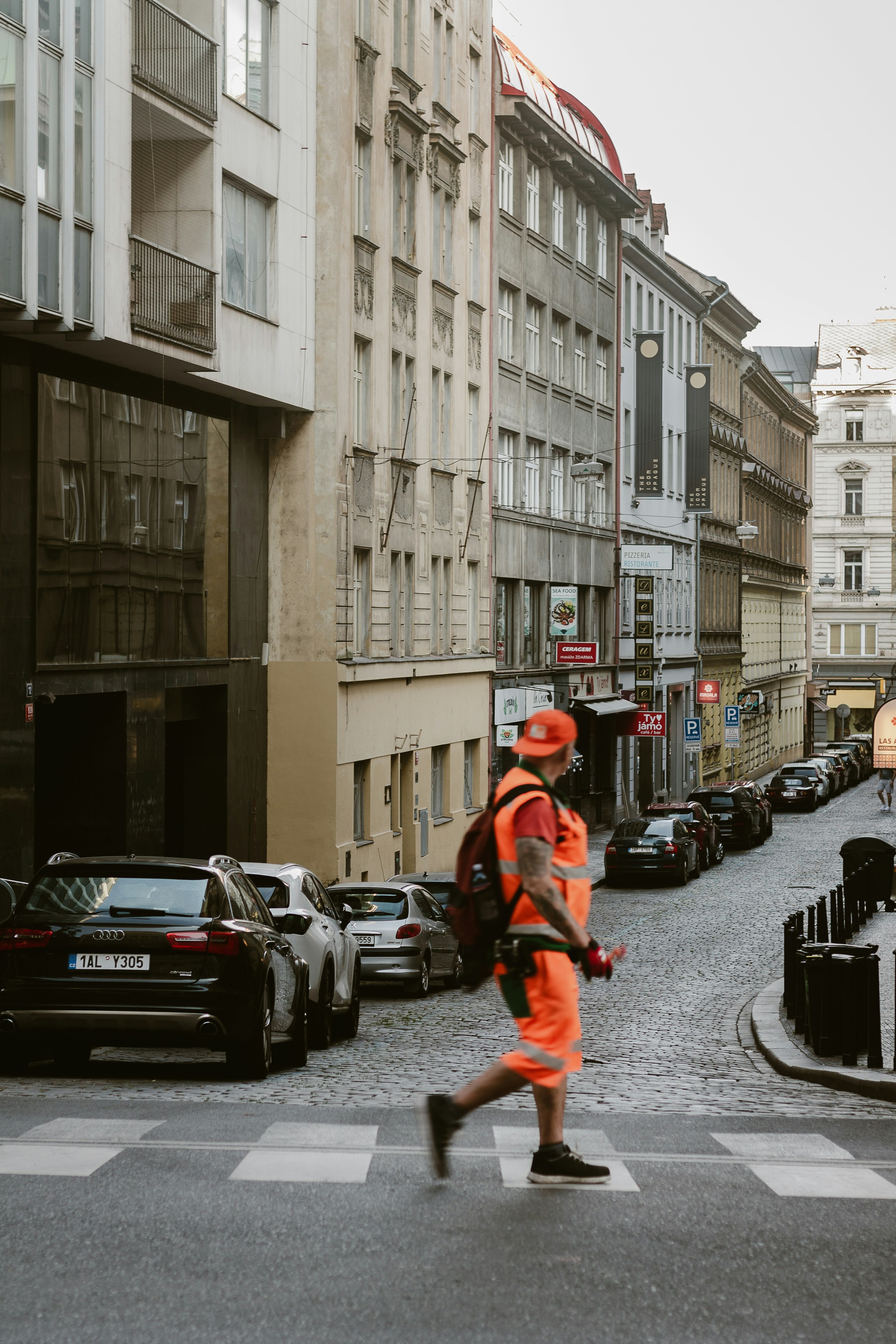 High-Visibility Worker Crossing a Historic Street