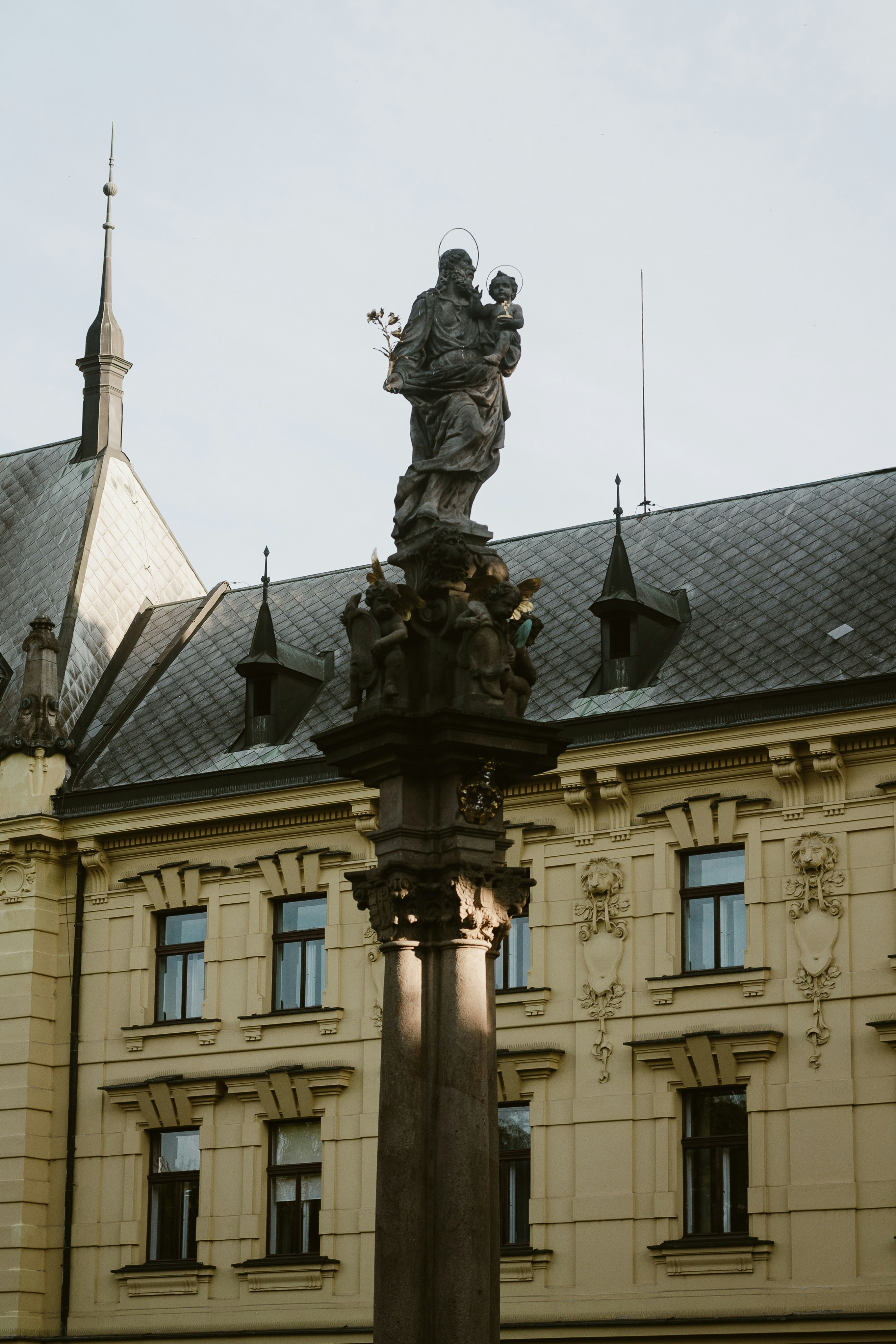 Statue Portrait: A Sacred Monument Rising Over Baroque Architecture