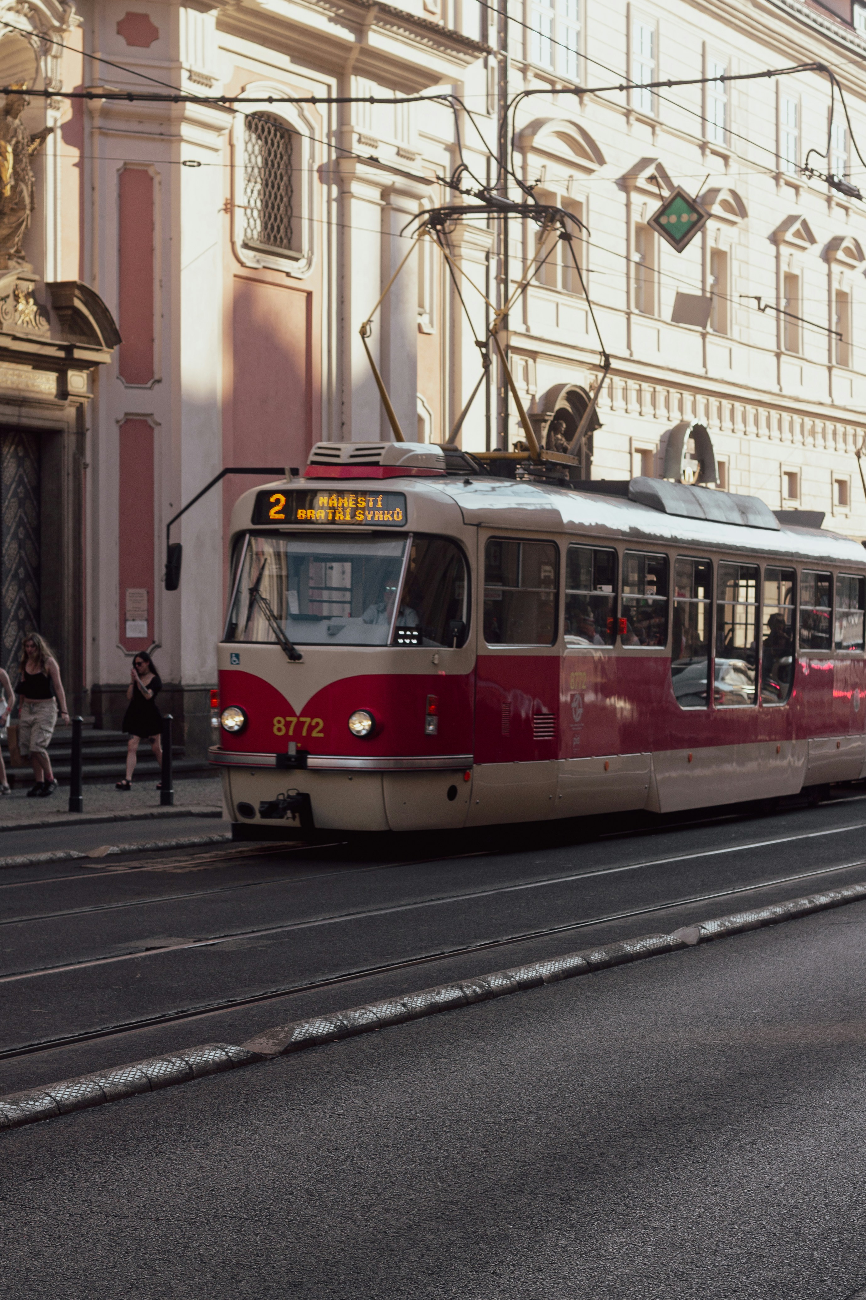 Crimson Streetcar Gliding Past Ornate Facades