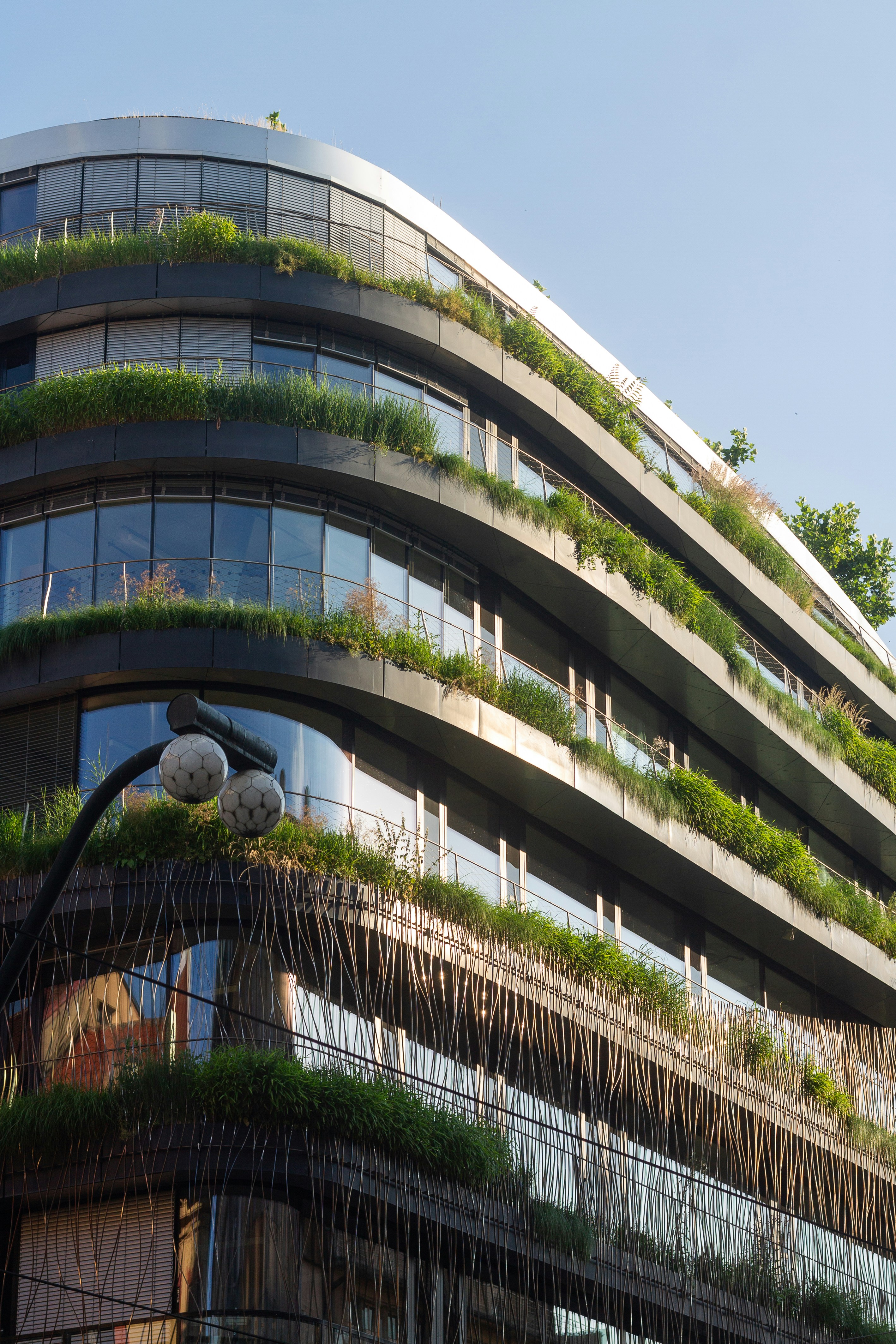 Tiered Green: A Modern Facade Framed by Urban Sky