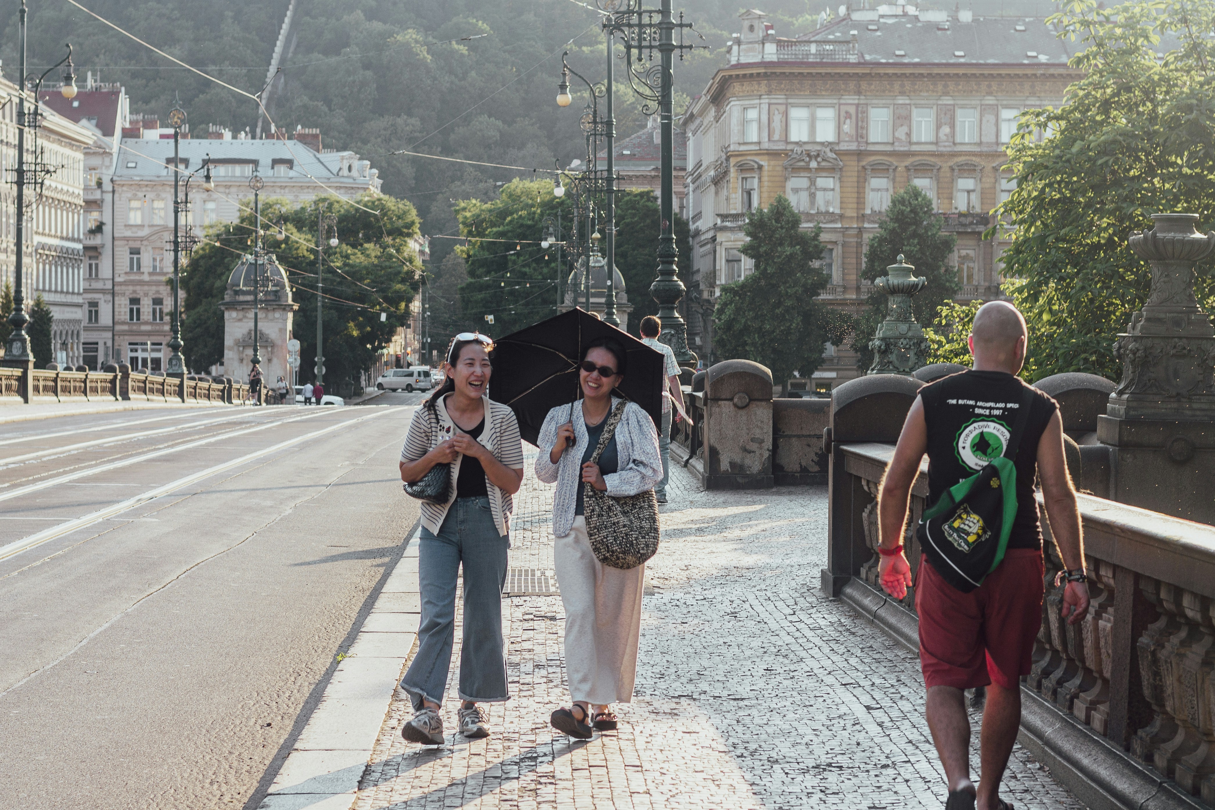 Stroll Under City Light: Umbrella Moments on a Riverside Bridge
