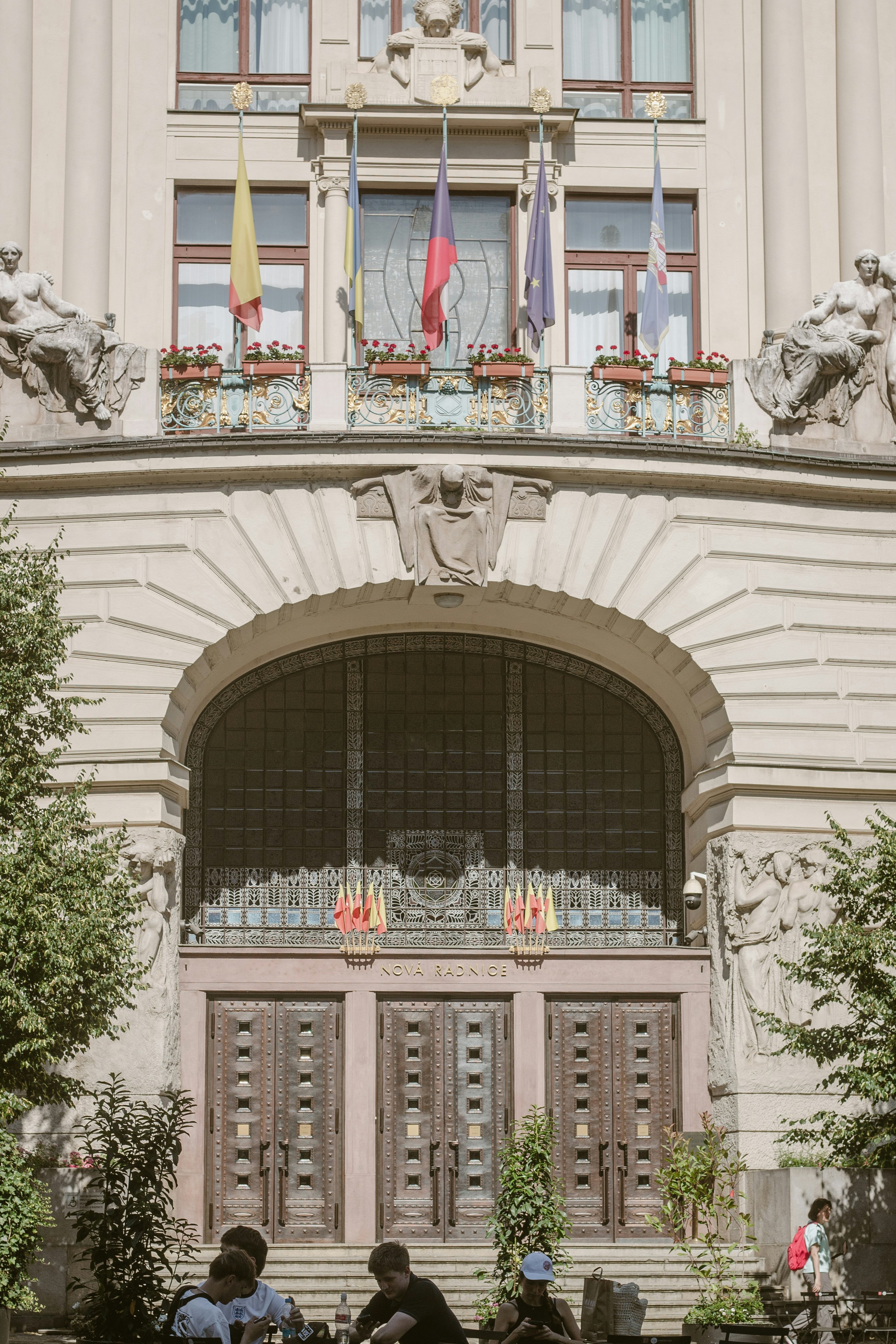 Flagpelt Facade: A Historic Entrance Framed by Flags and Stone Carvings