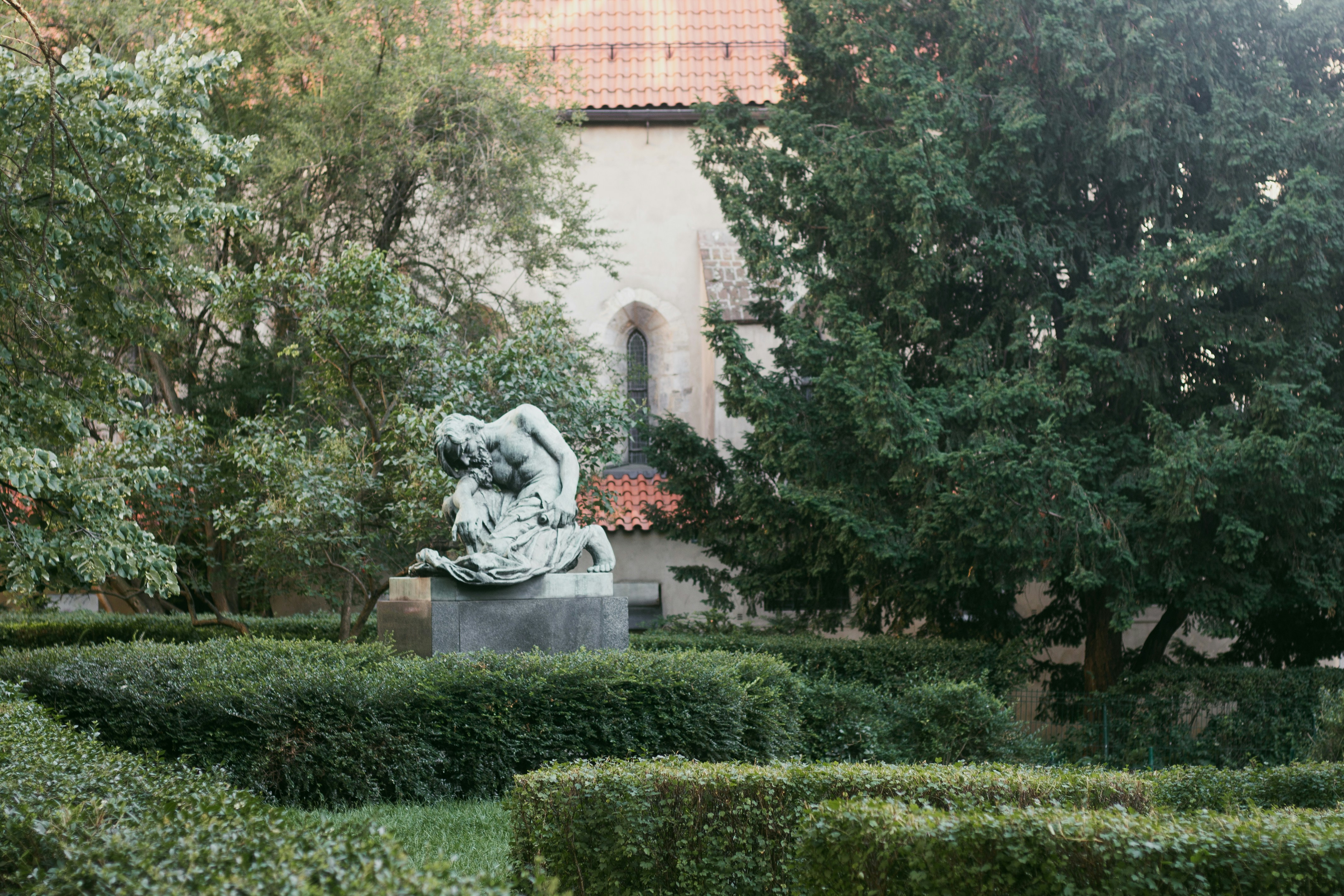 Stone Embrace: a Sculpted Moment Amid Pruned Hedges