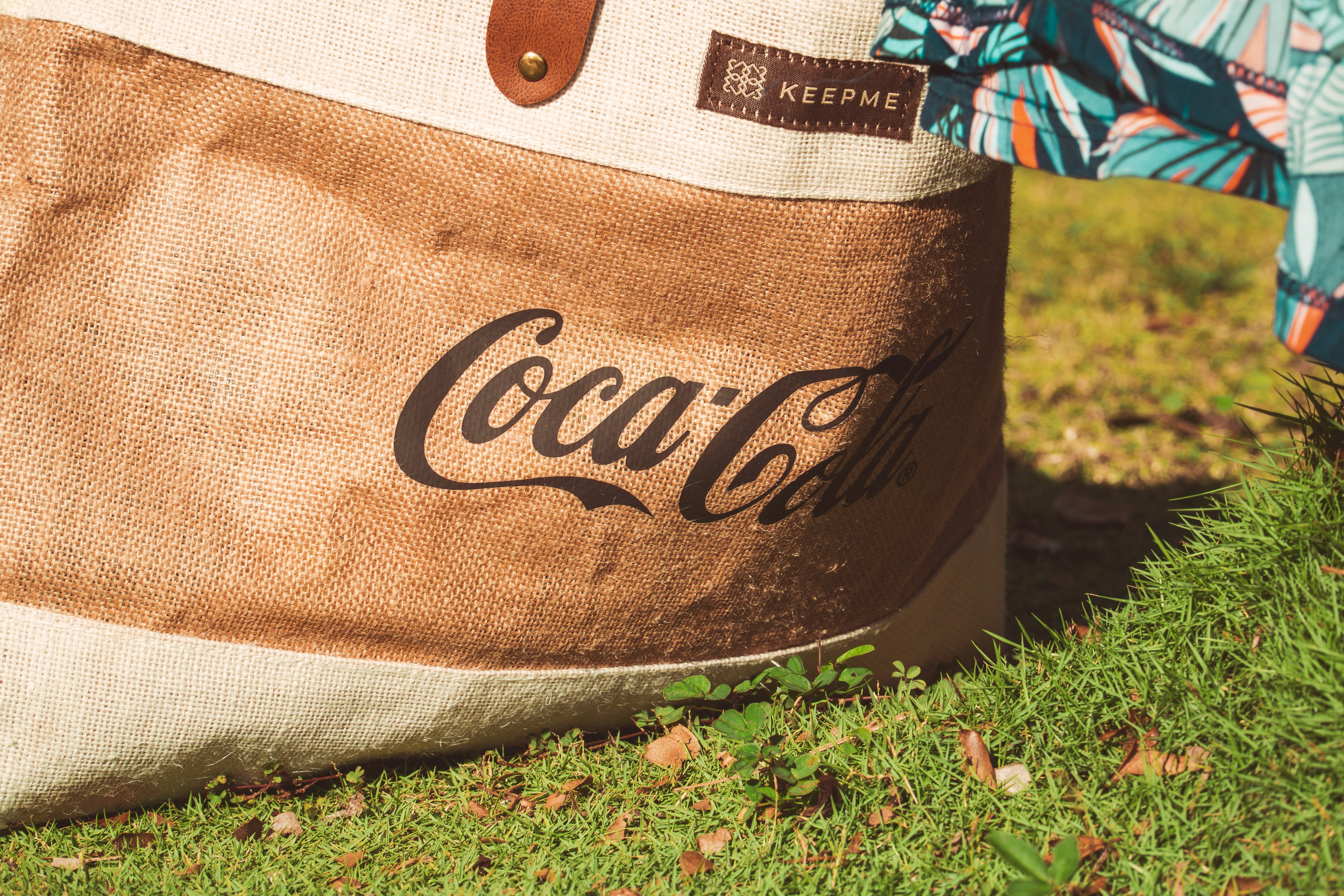 Coca-Cola Picnic: A Coca-Cola tote bag rests in the grass at Los Bajos de Patillas, Puerto Rico, catching bright island sunlight.