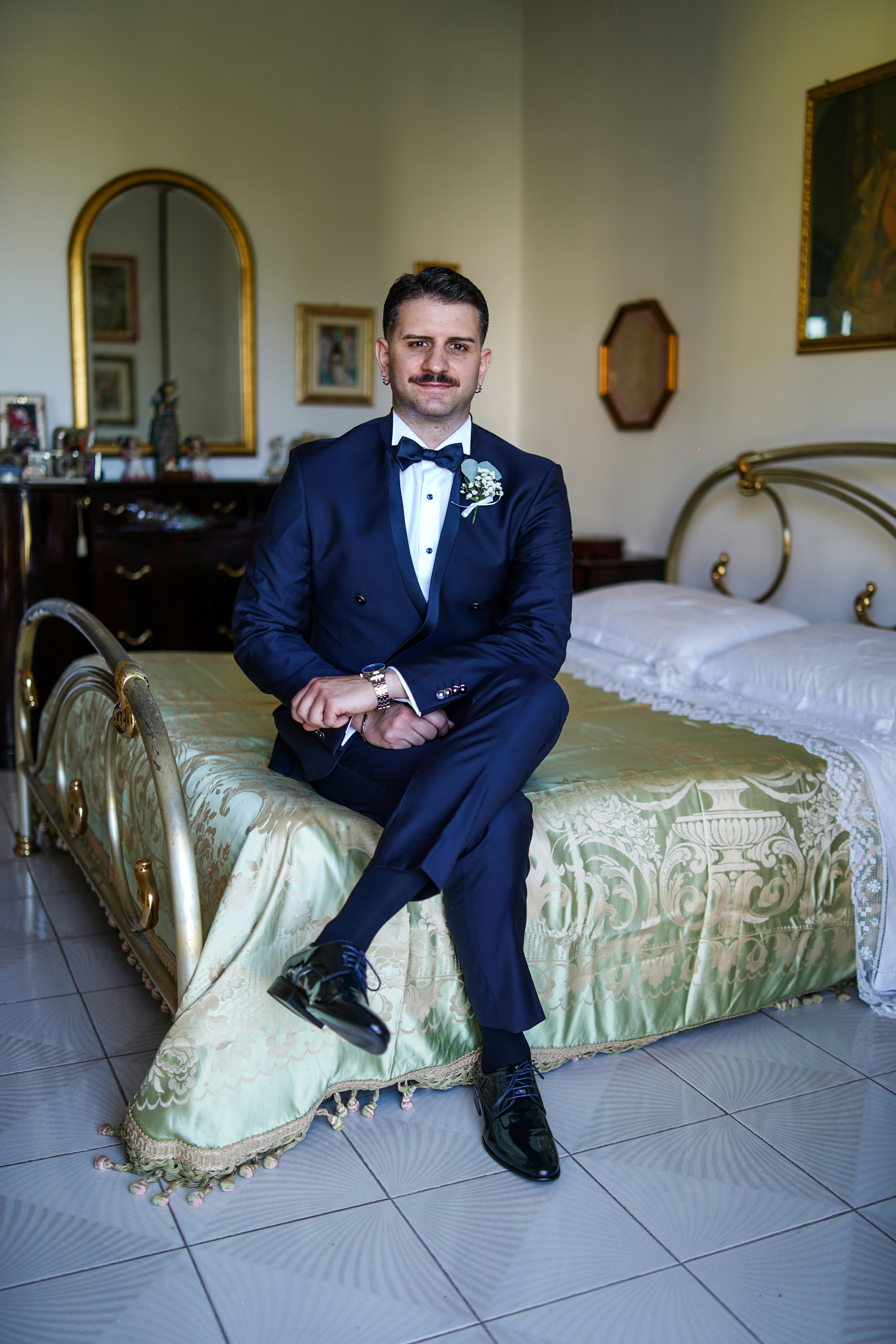 Gentleman in Navy Tuxedo: Quiet Confidence in a Lavish Bedroom Setting