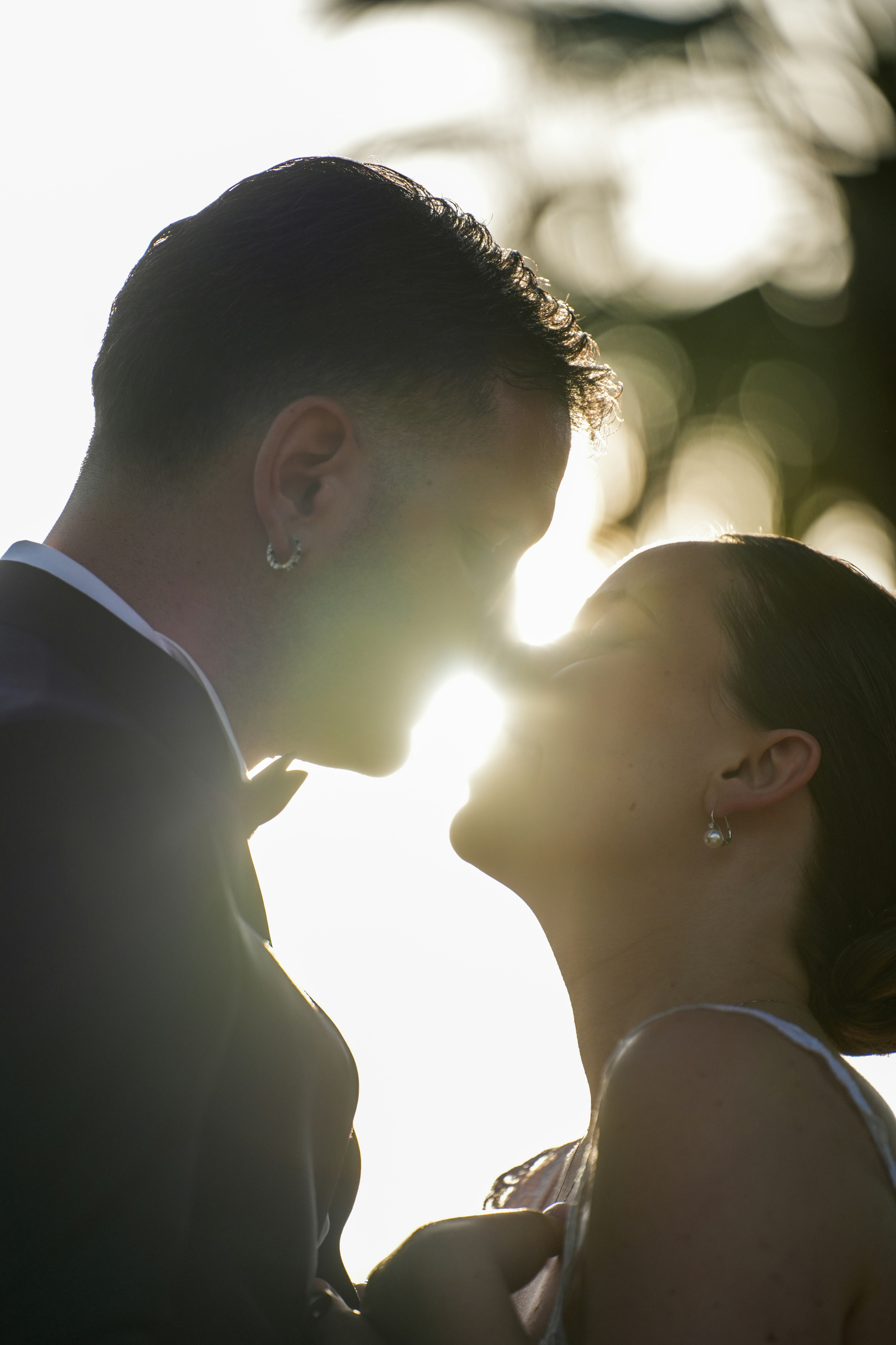 Backlit Embrace: A Tender Kiss Framed by Soft Rails of Light