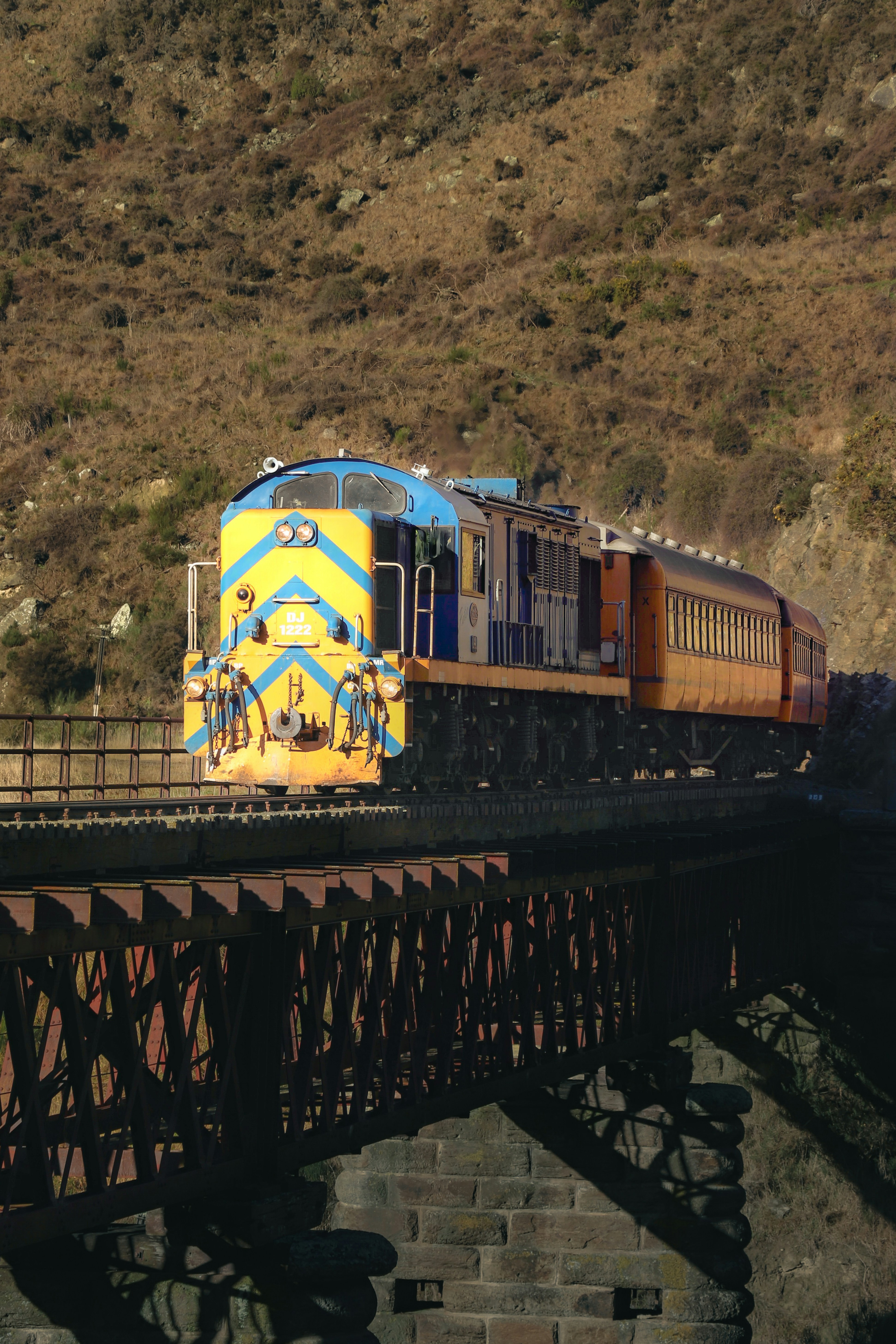 Blue Highway: A Bright Locomotive Crossing a Historic Bridge