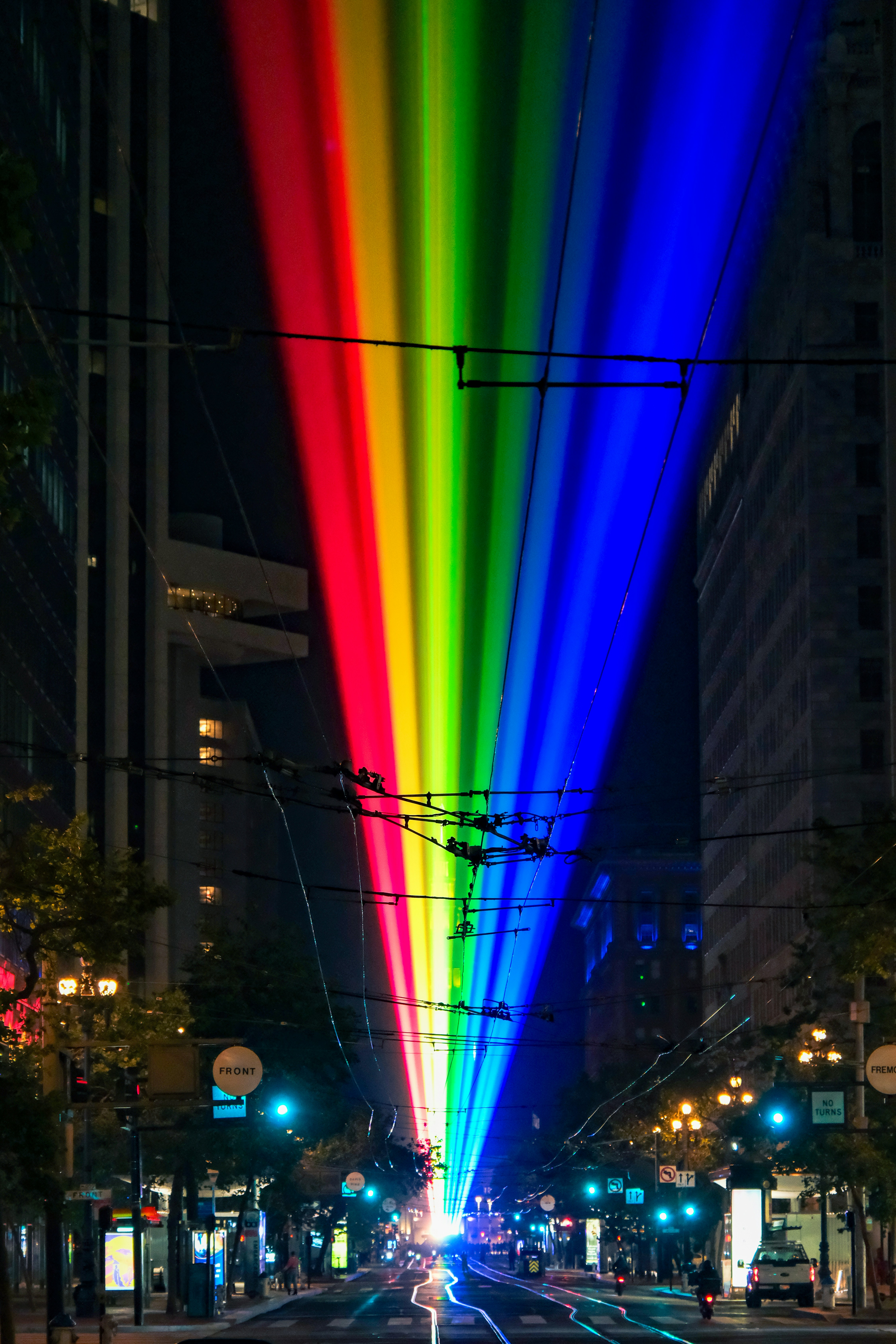Chromatic Convergence: Neon Rainbow Pierces a Night Street