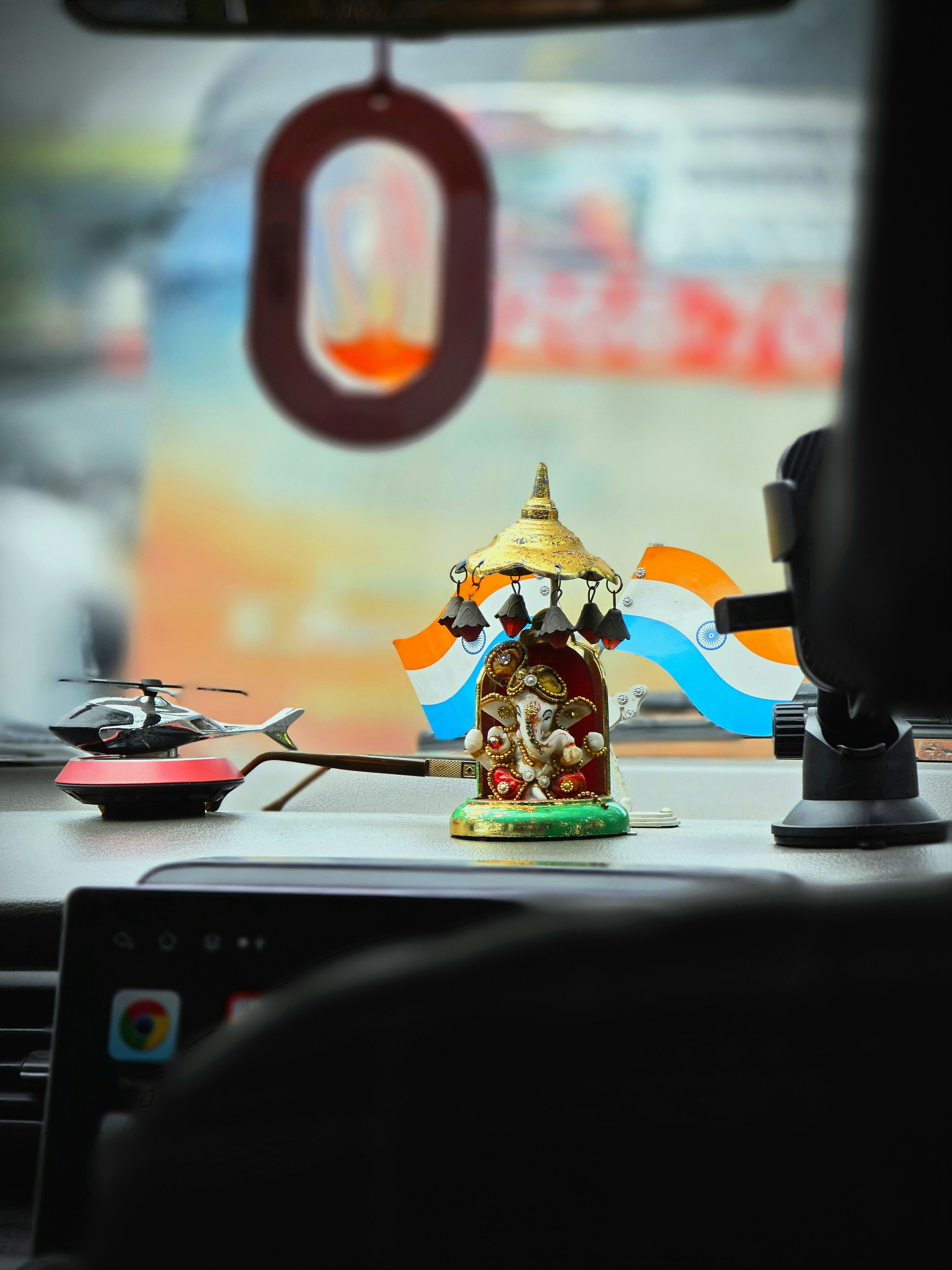 Miniature Shrine on the Dashboard: A Dragonfly of Color Between Indian Flag Motifs