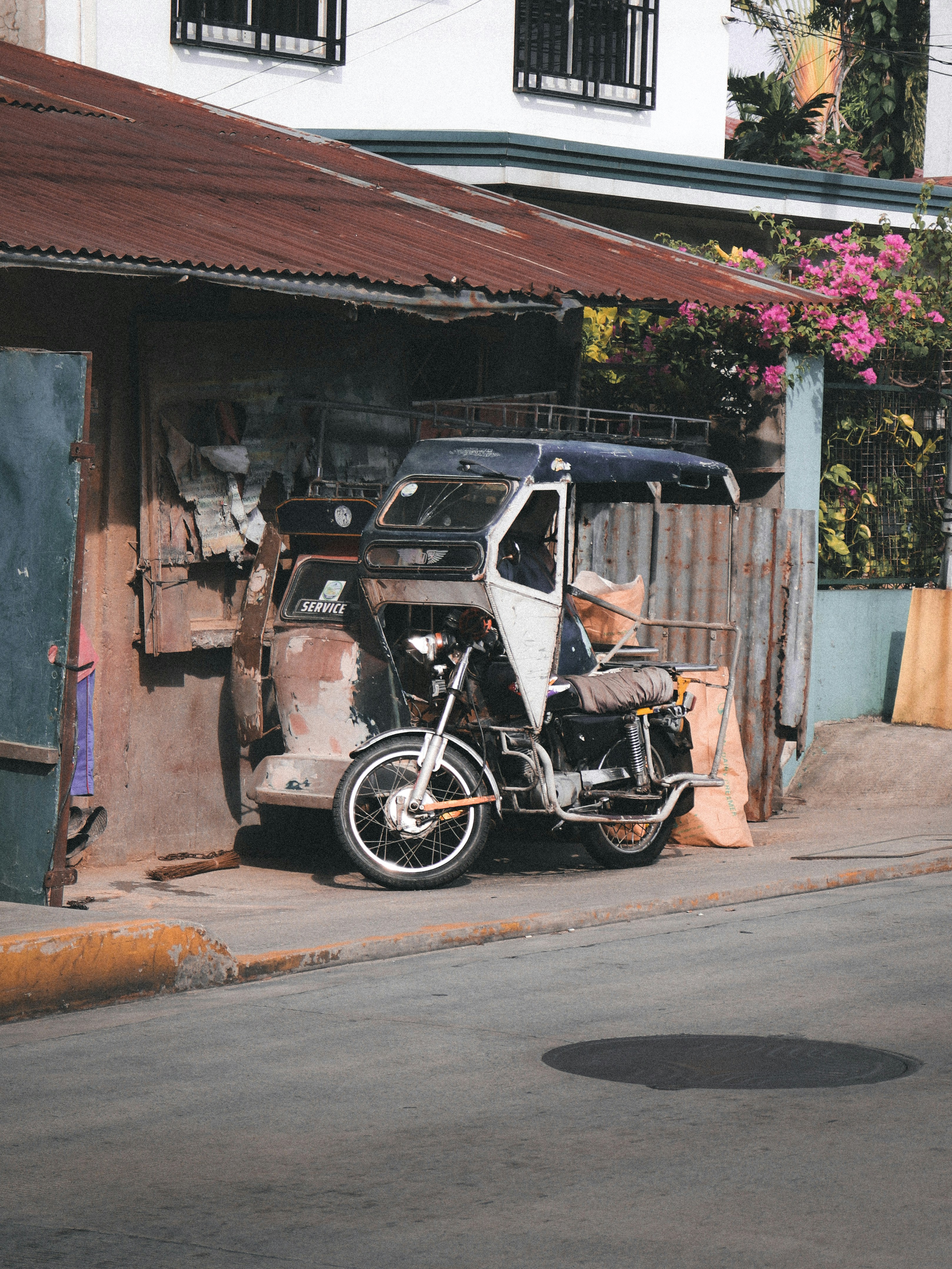 The Pedicab in Front of a Faded Workshop