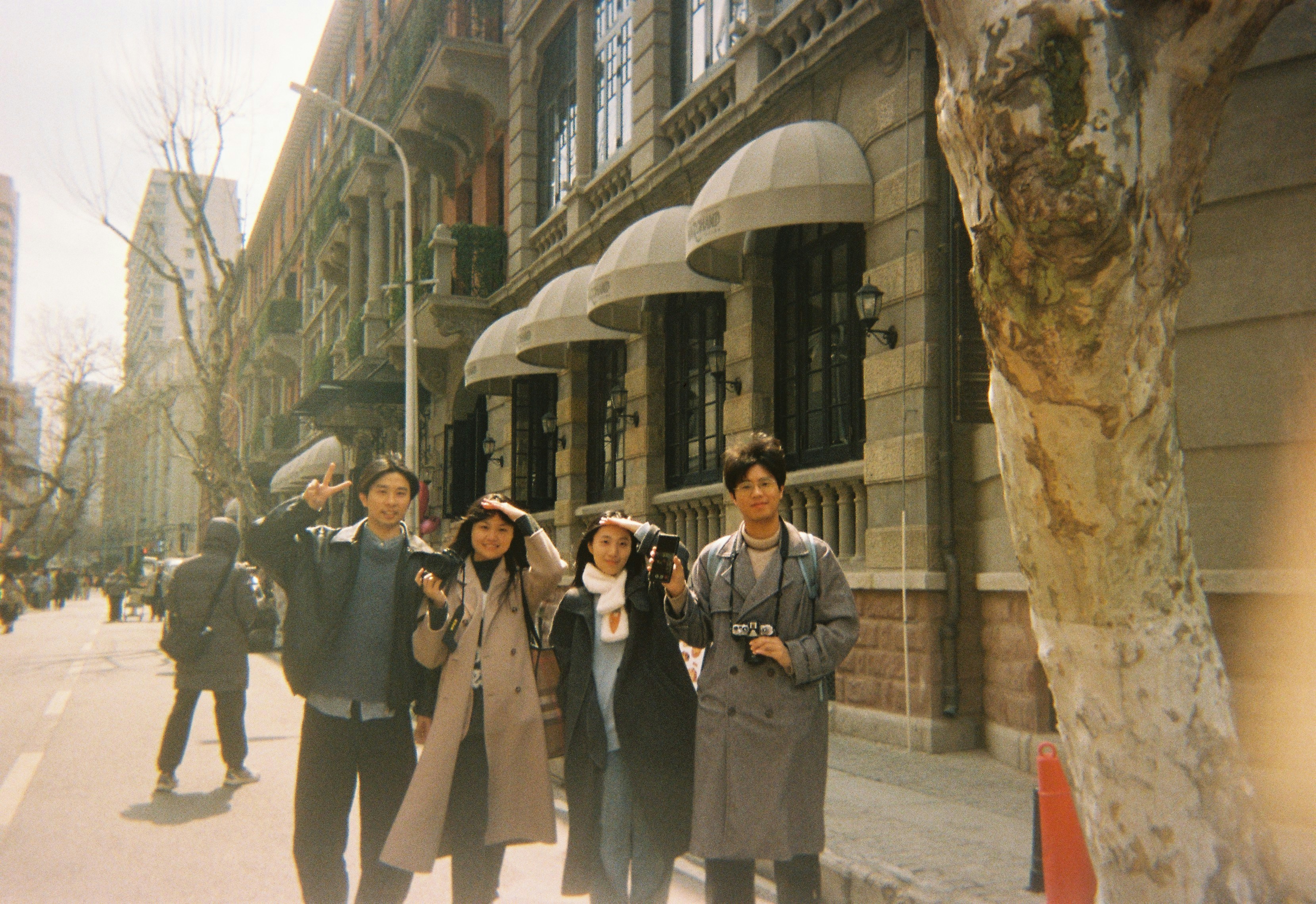 Friends on a sunlit city street under arcaded storefronts