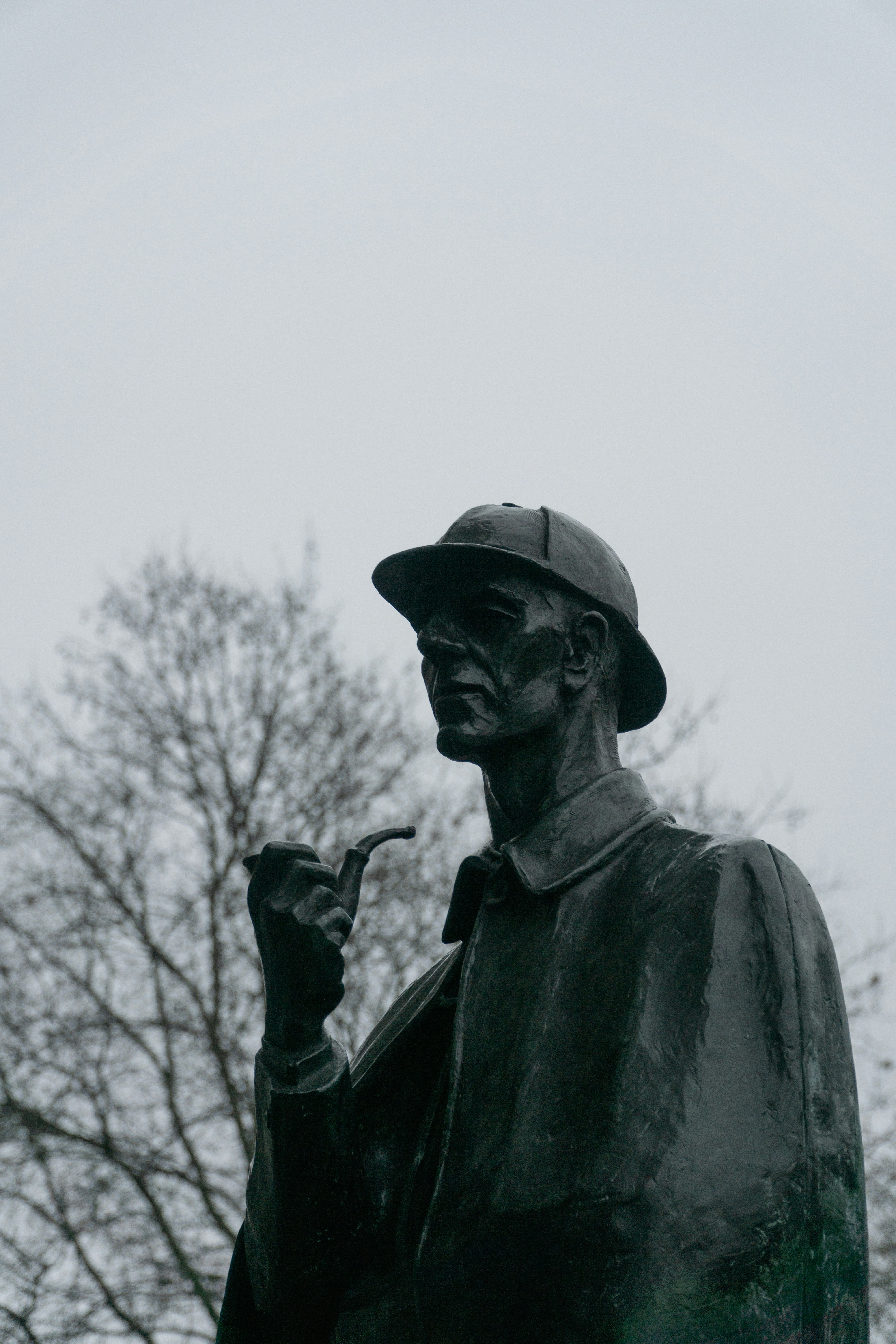 Pipe-smoking Detective: A Bronze Figure Anchored by Quiet Gaze