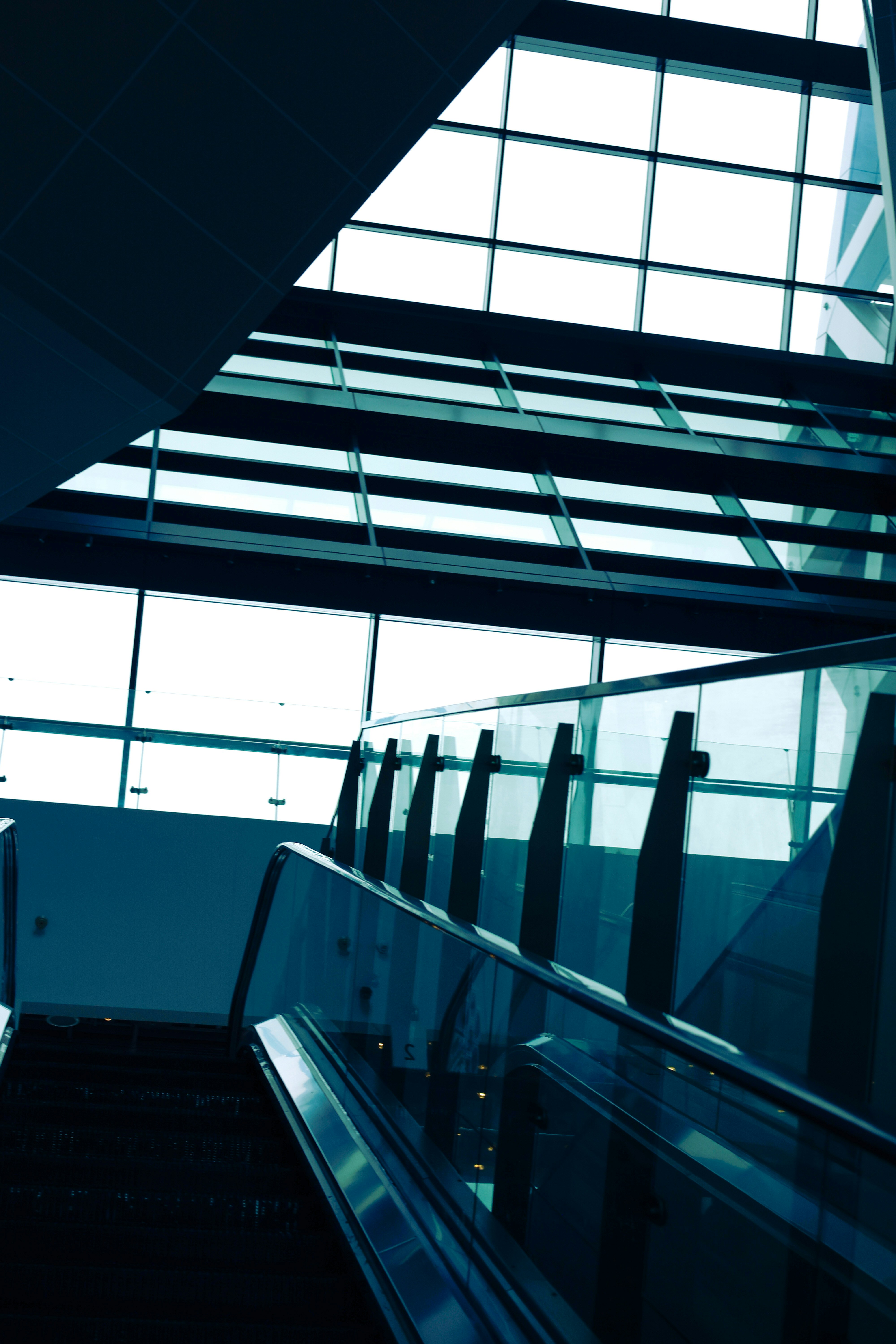 Glazed Geometry: An Ascending Glass Atrium in Cool Blue Light