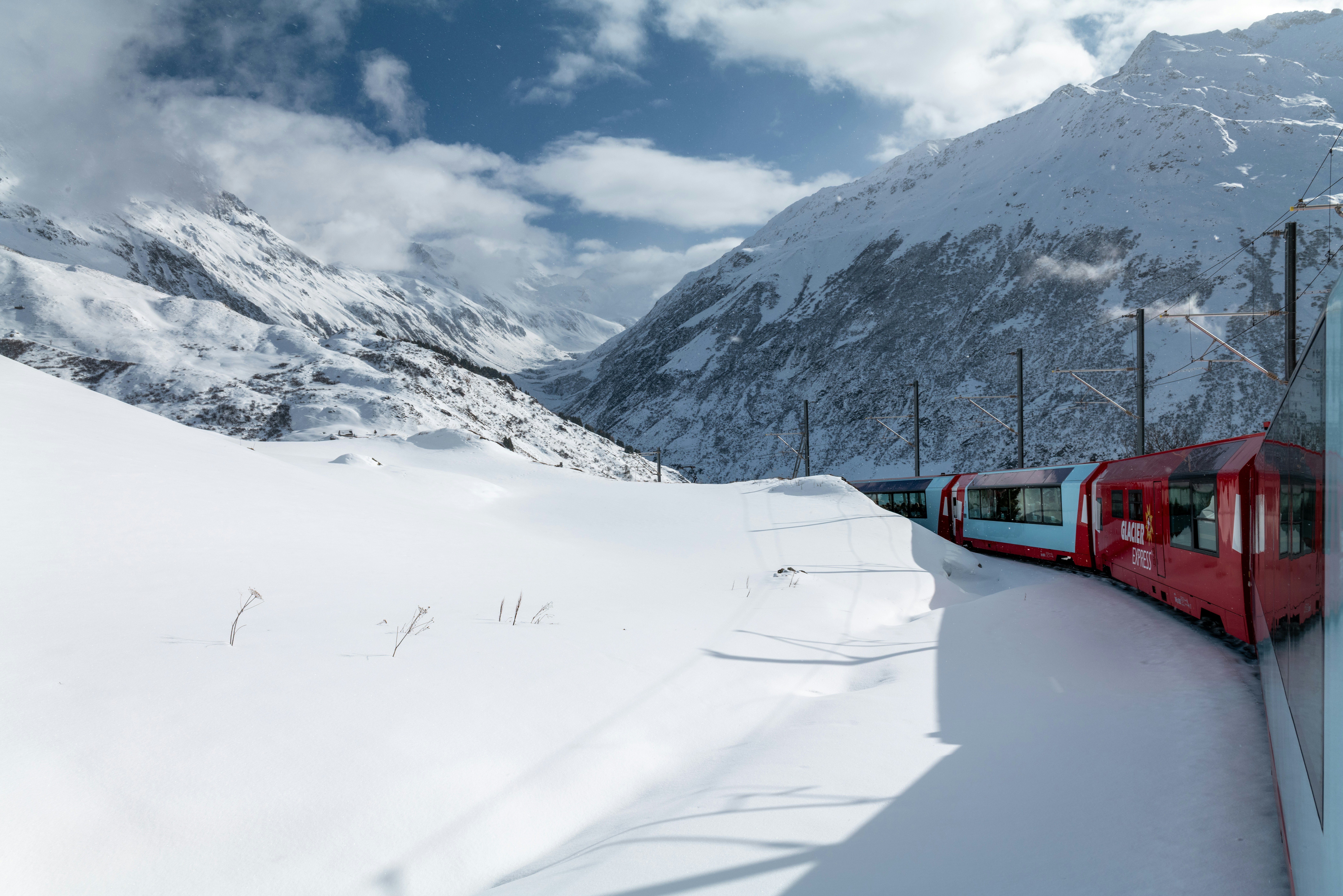 Snowbound Rails: A Red Train Wends Through Alpine Quiet