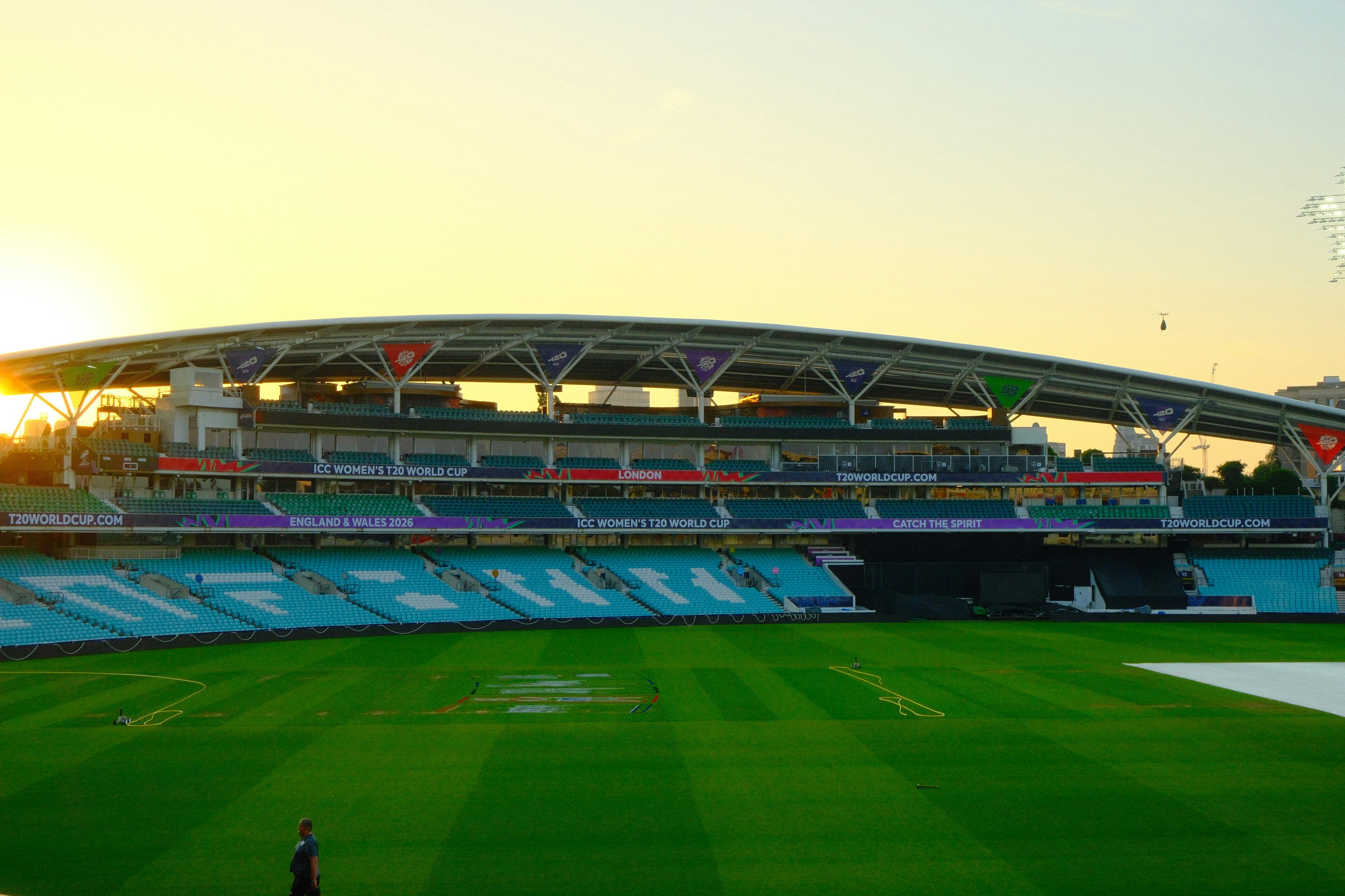 Sunlit Stadium: Empty Field Beneath a Waving Roof