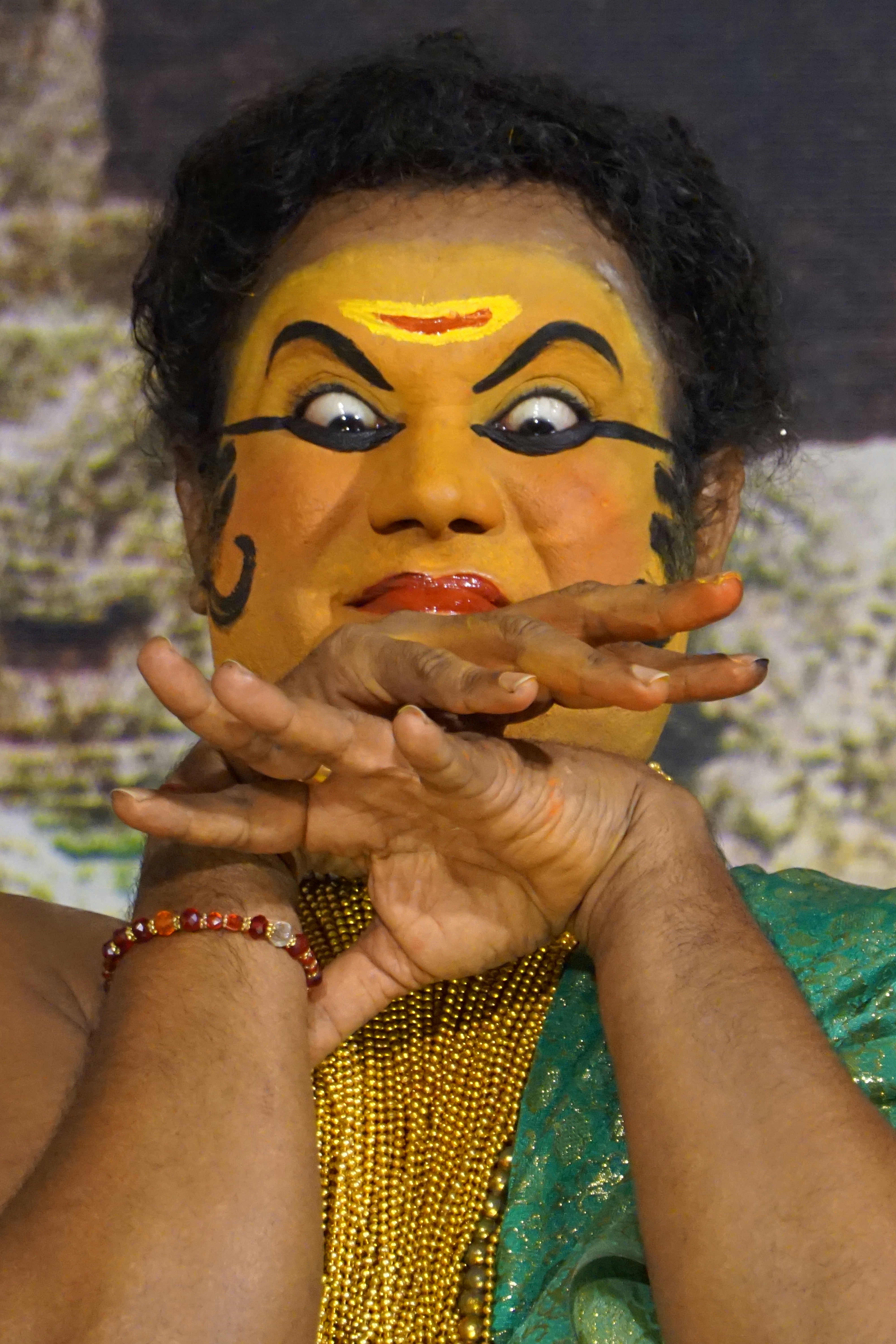 Face Painted as a Dramatic Mask Framed by Hands in Motion