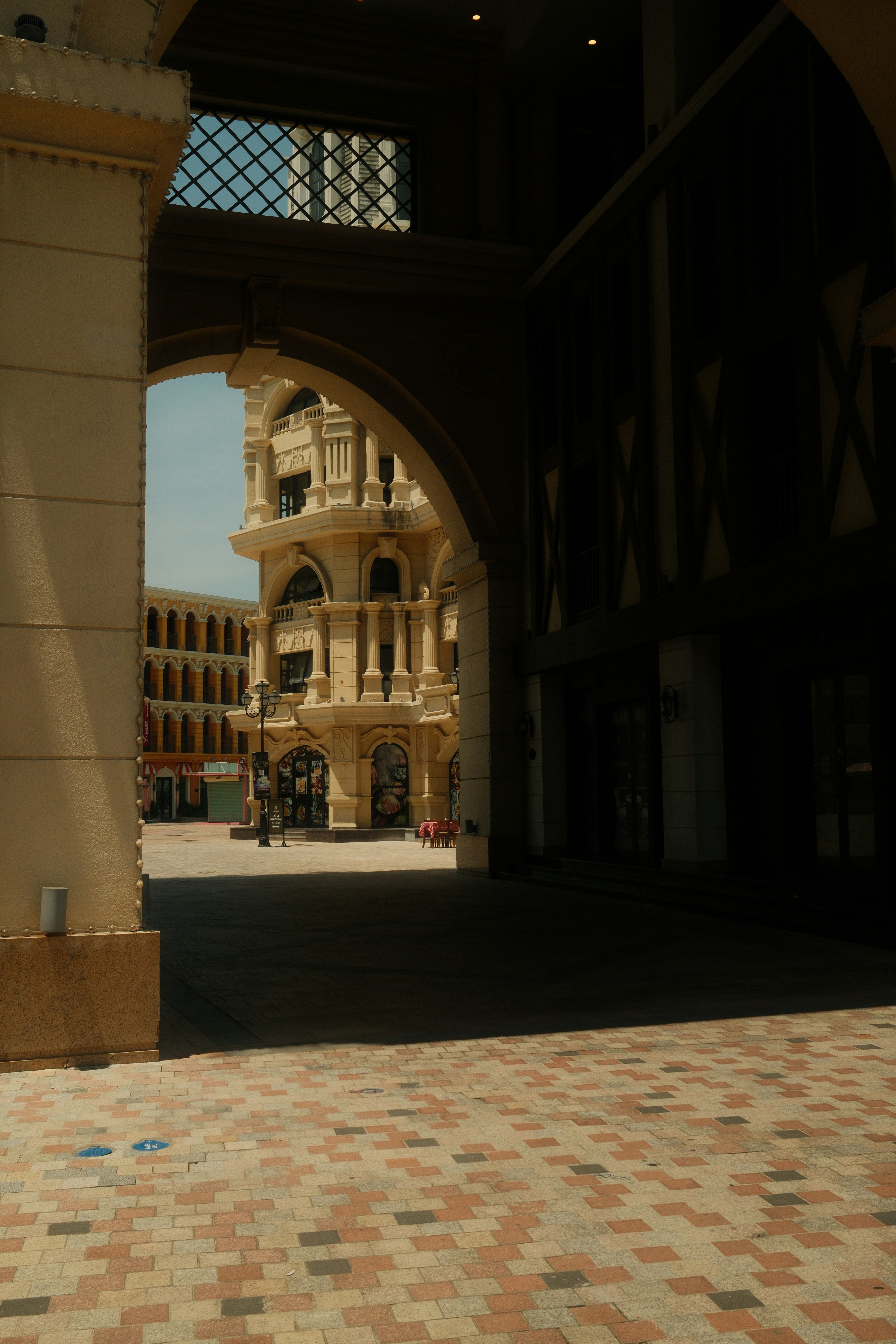 Archway to the Towering Facade: A Quiet Courtyard in Warm Light