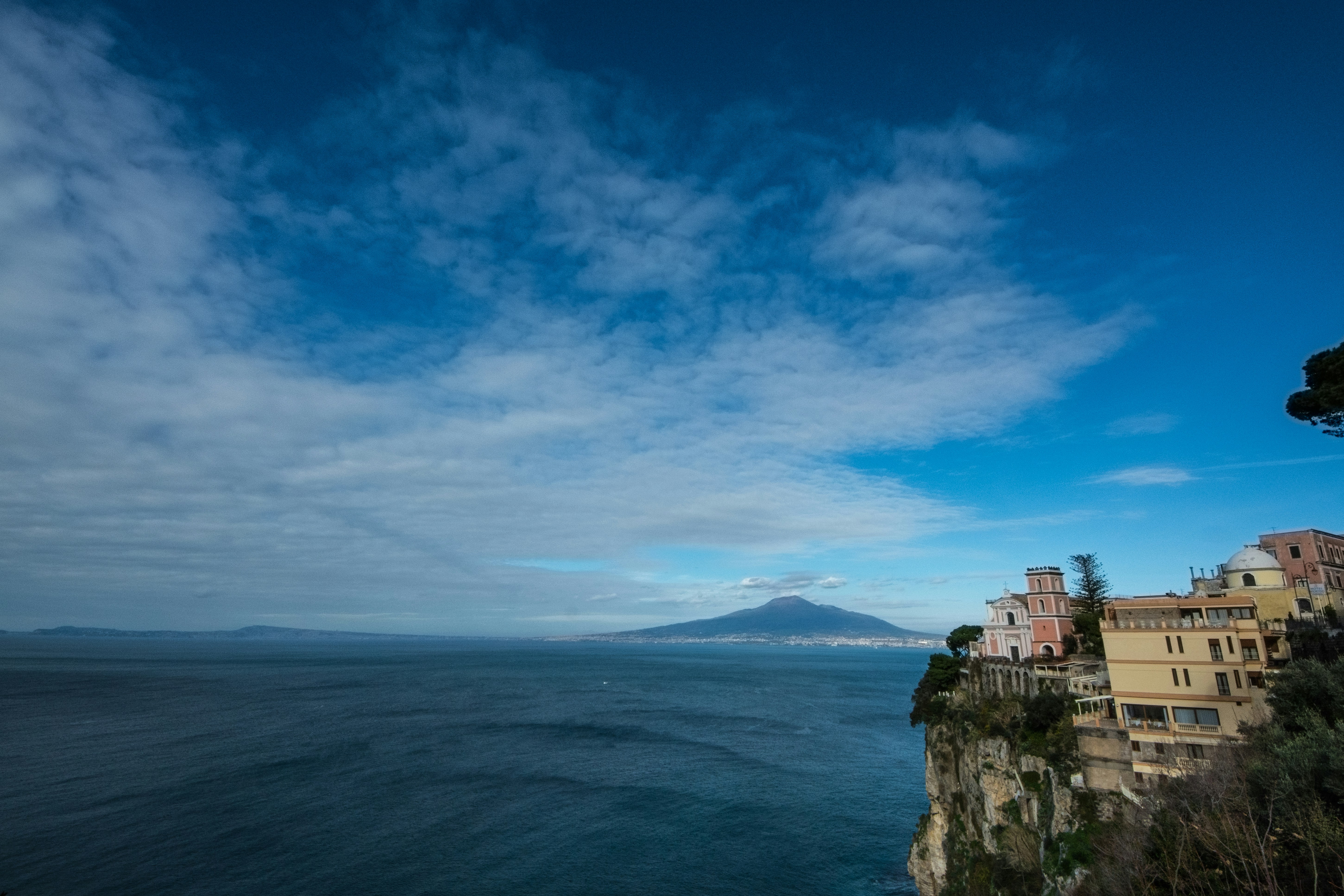 Cliffside Village Overlooking a Calm Sea Under a Wide Sky