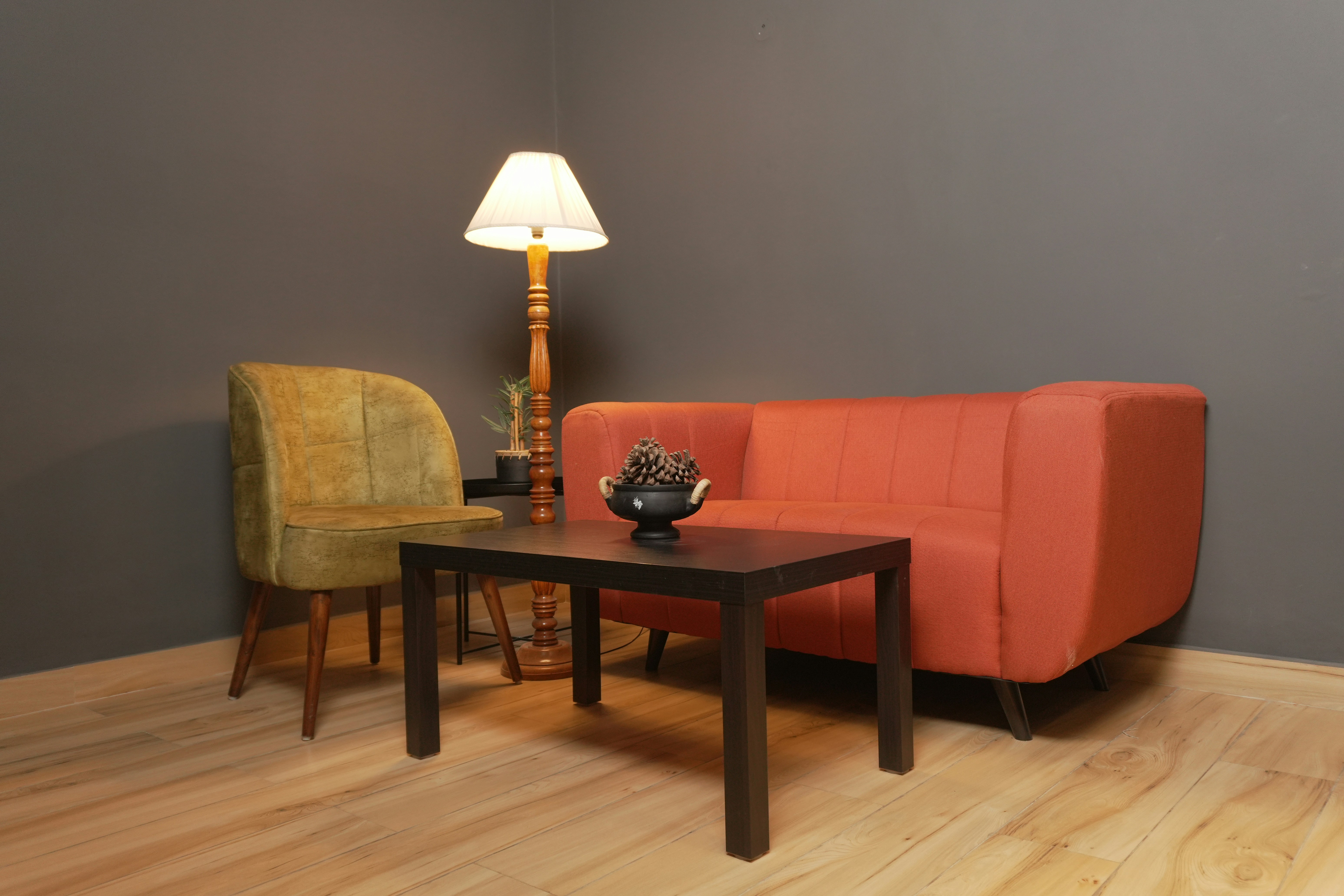 Cozy Corner: Vintage Chair, Red Sofa, and Warm Lamp in a Quiet Living Room