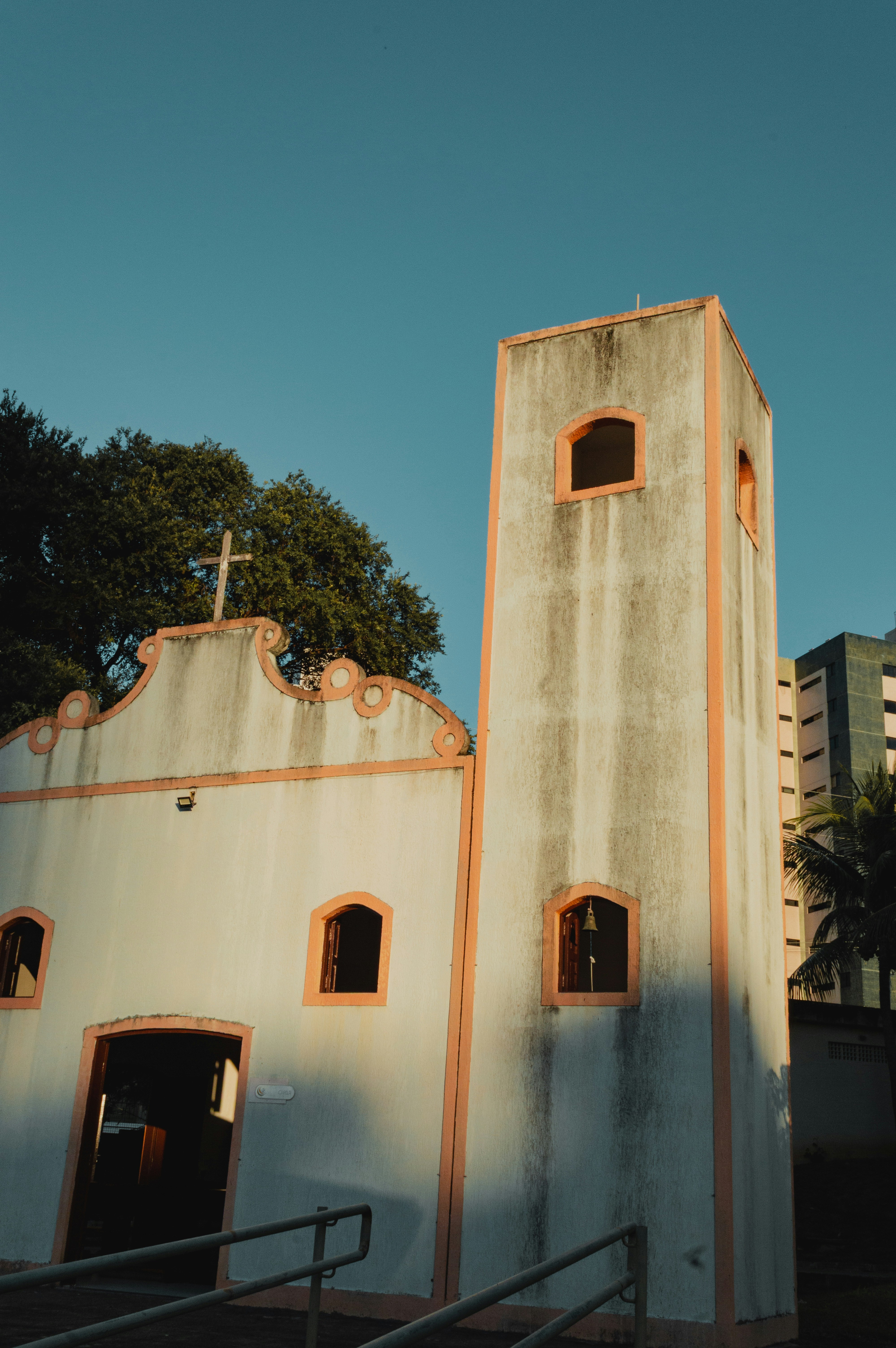 Sunlit Mission Tower Standing Beside a Curved-Top Facade