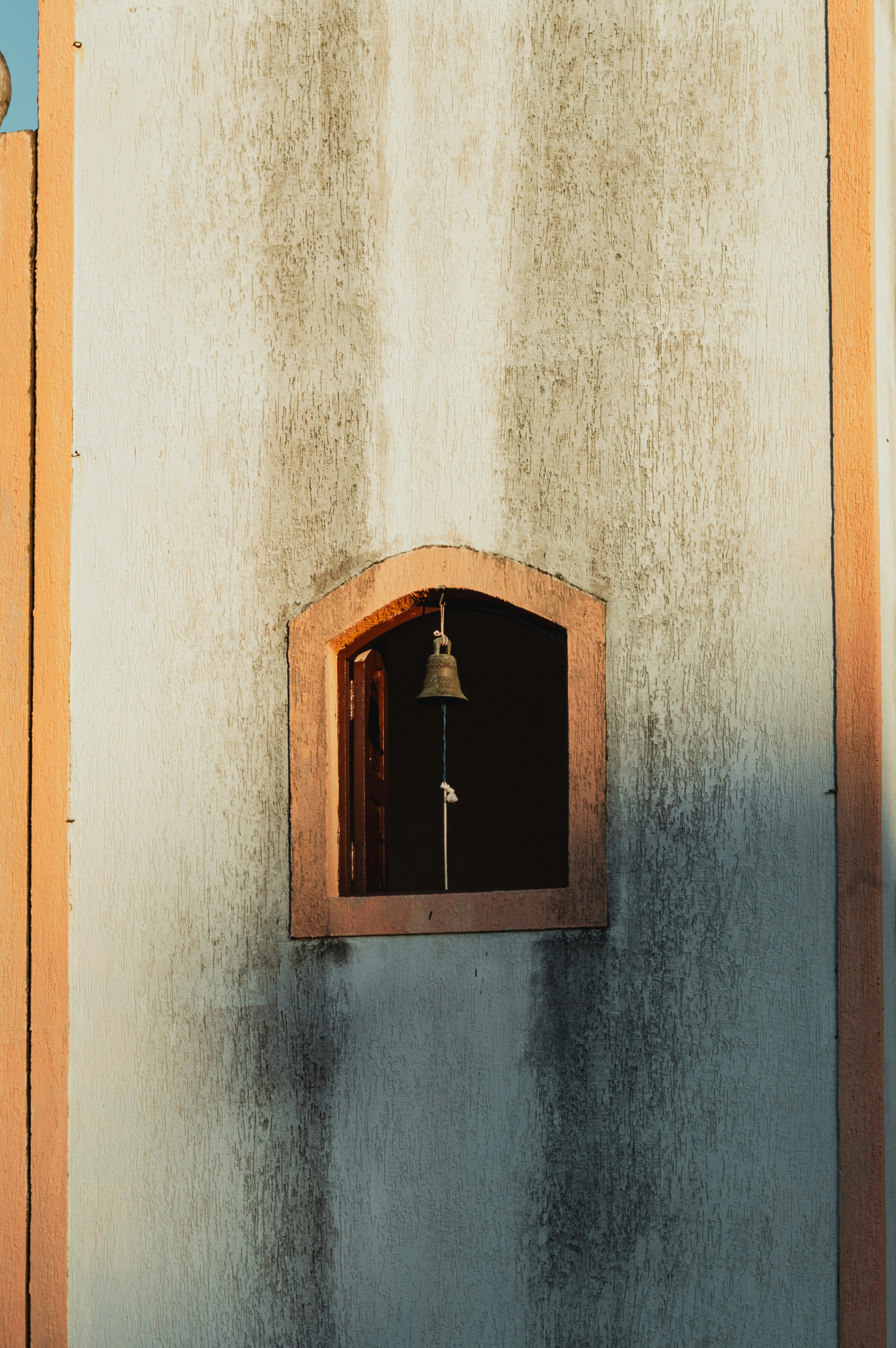 Bell Tower Window: Light and Patina on a Weathered Wall