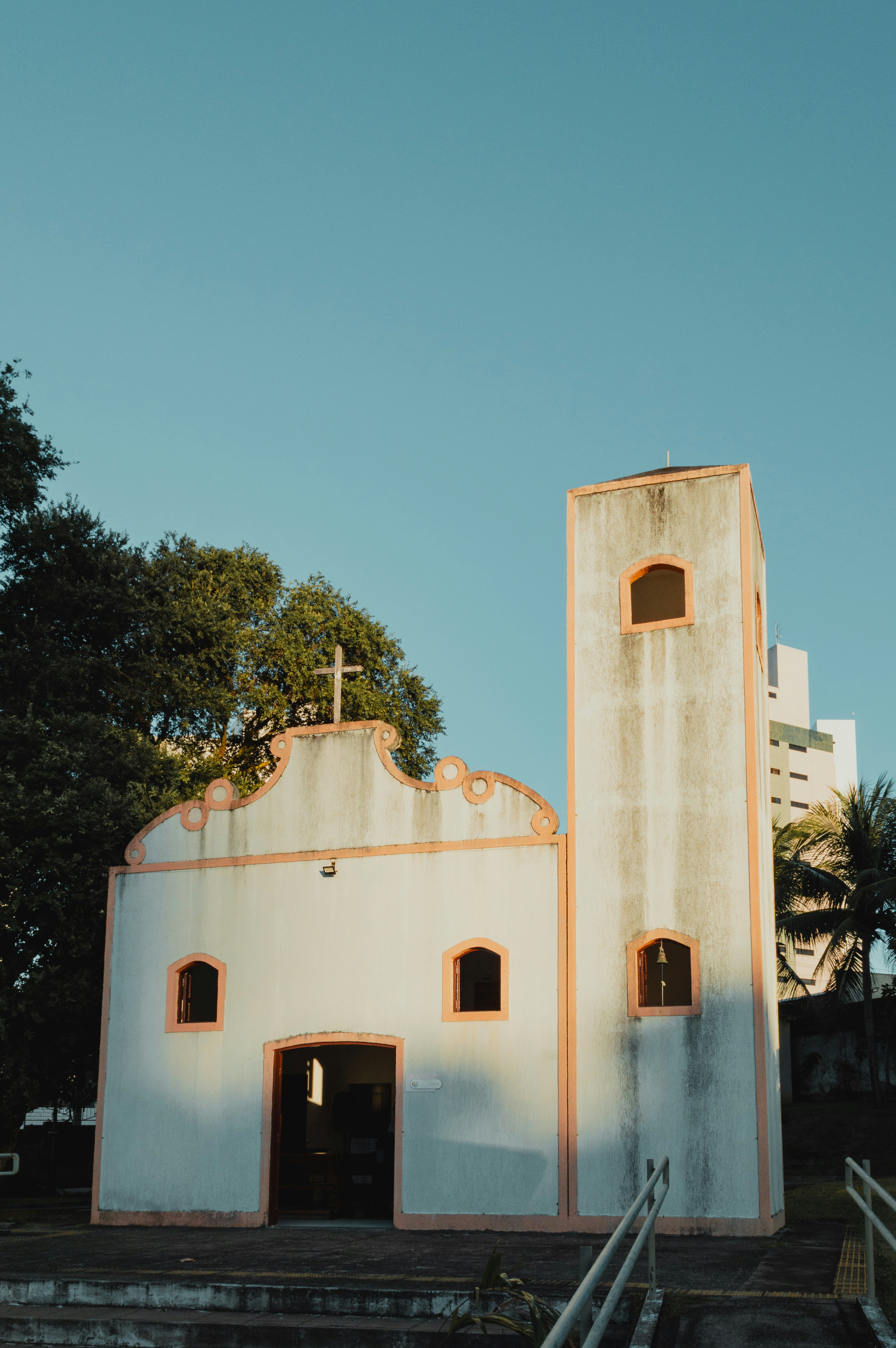 Sunlit chapel rising beside a calm coastal street