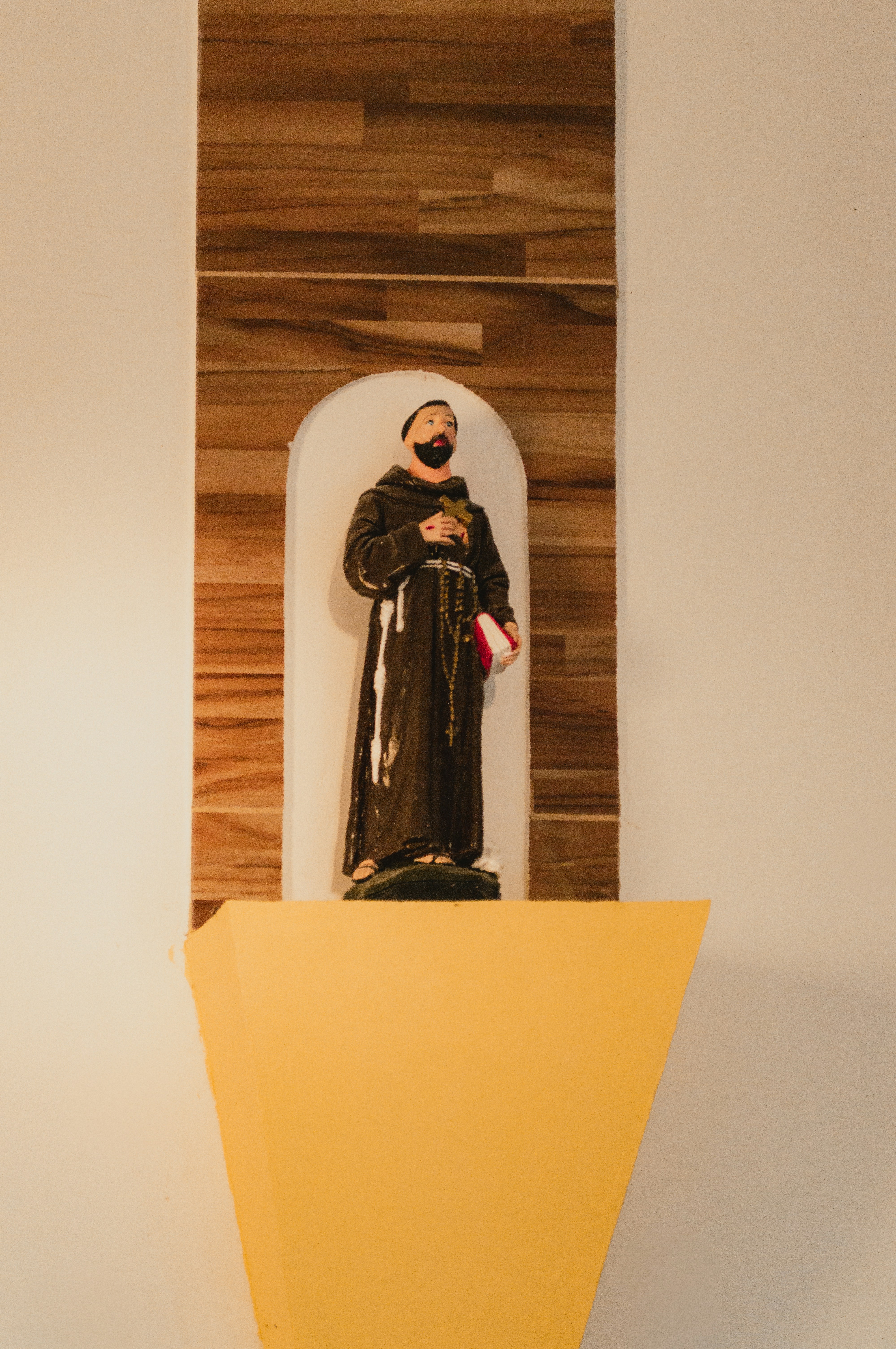 Holy Statue in a Modern Niche: A Quiet Shrine Above a Yellow Corner